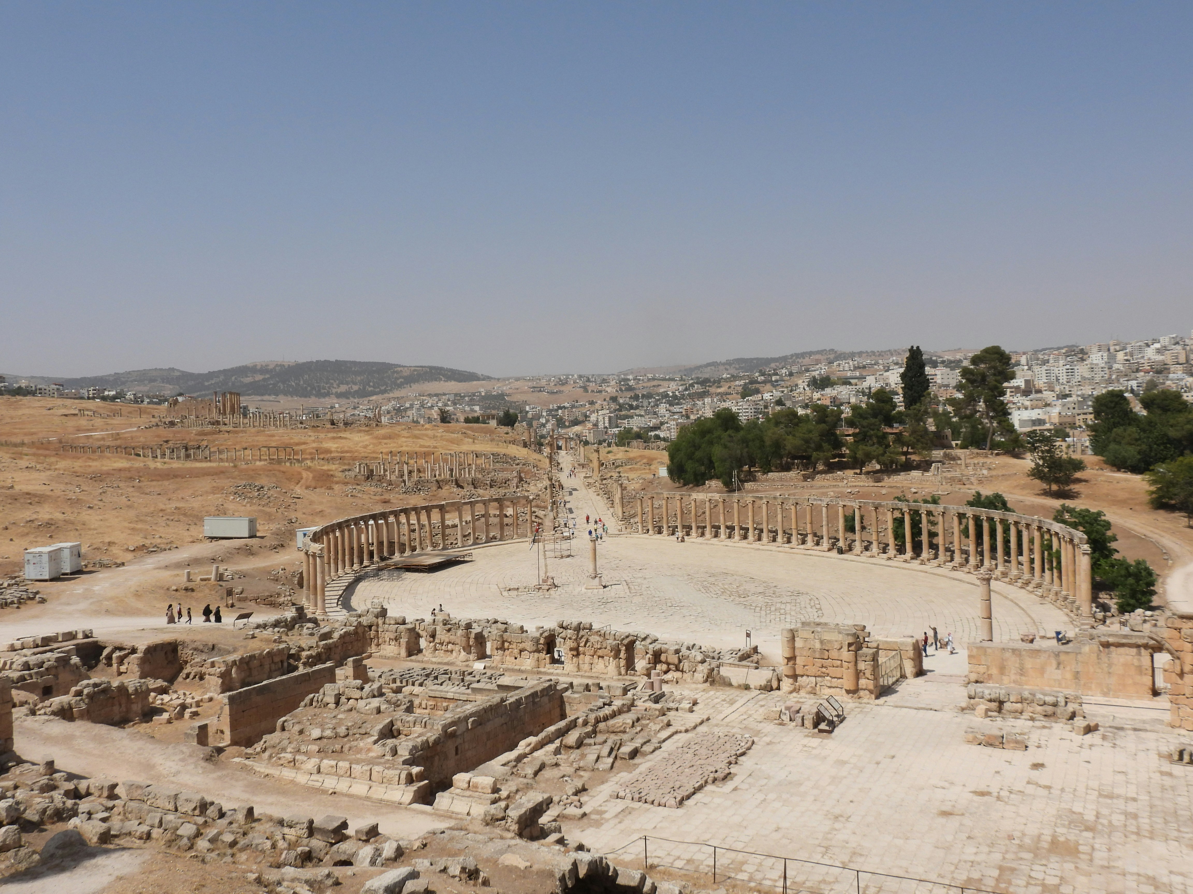 Ancient Theatre Amid Deserted Ruins Overlooking a Modern City