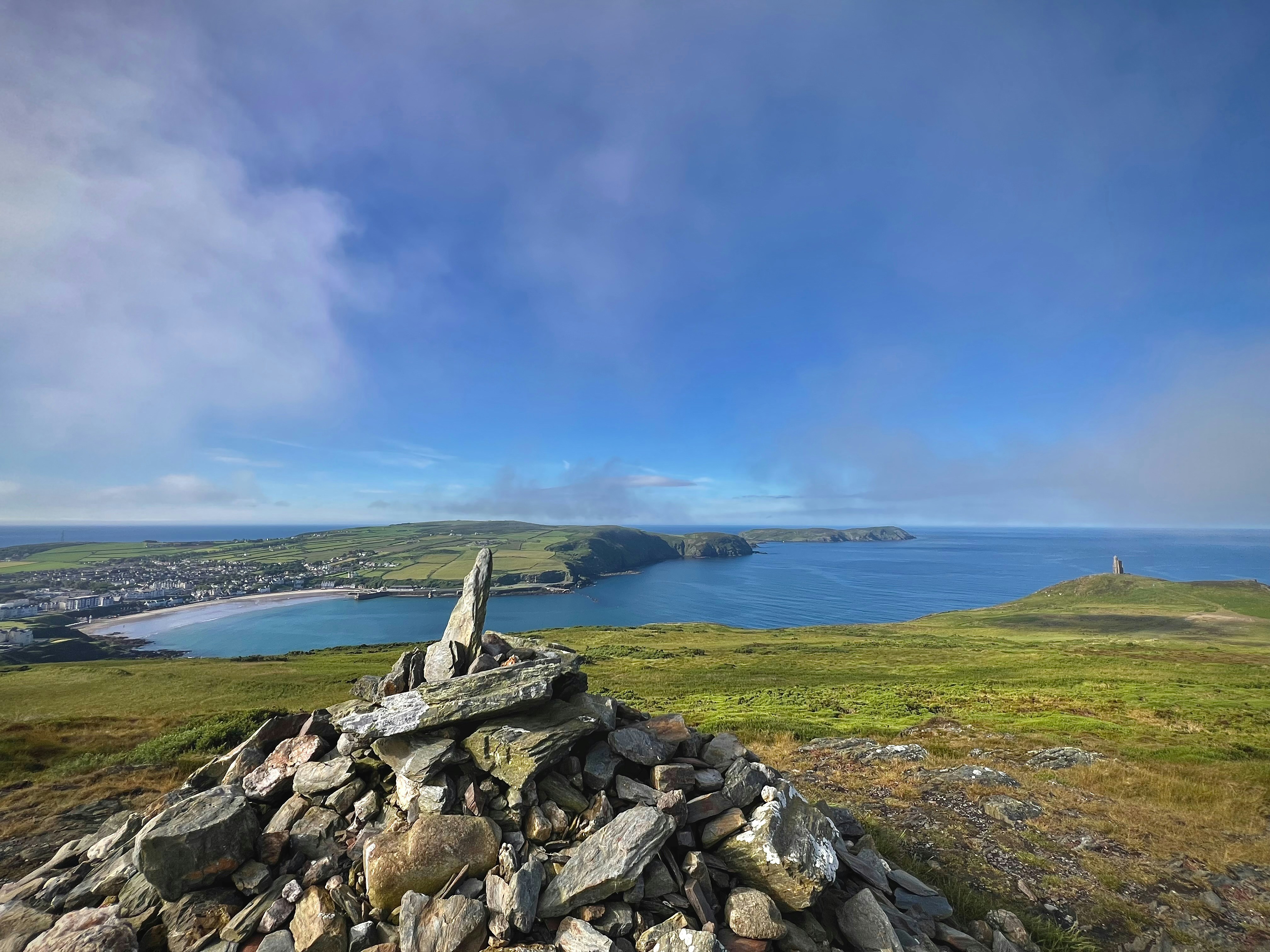 Stone Cairn Above the Cove: A Panoramic Moment at Distant Cliffs