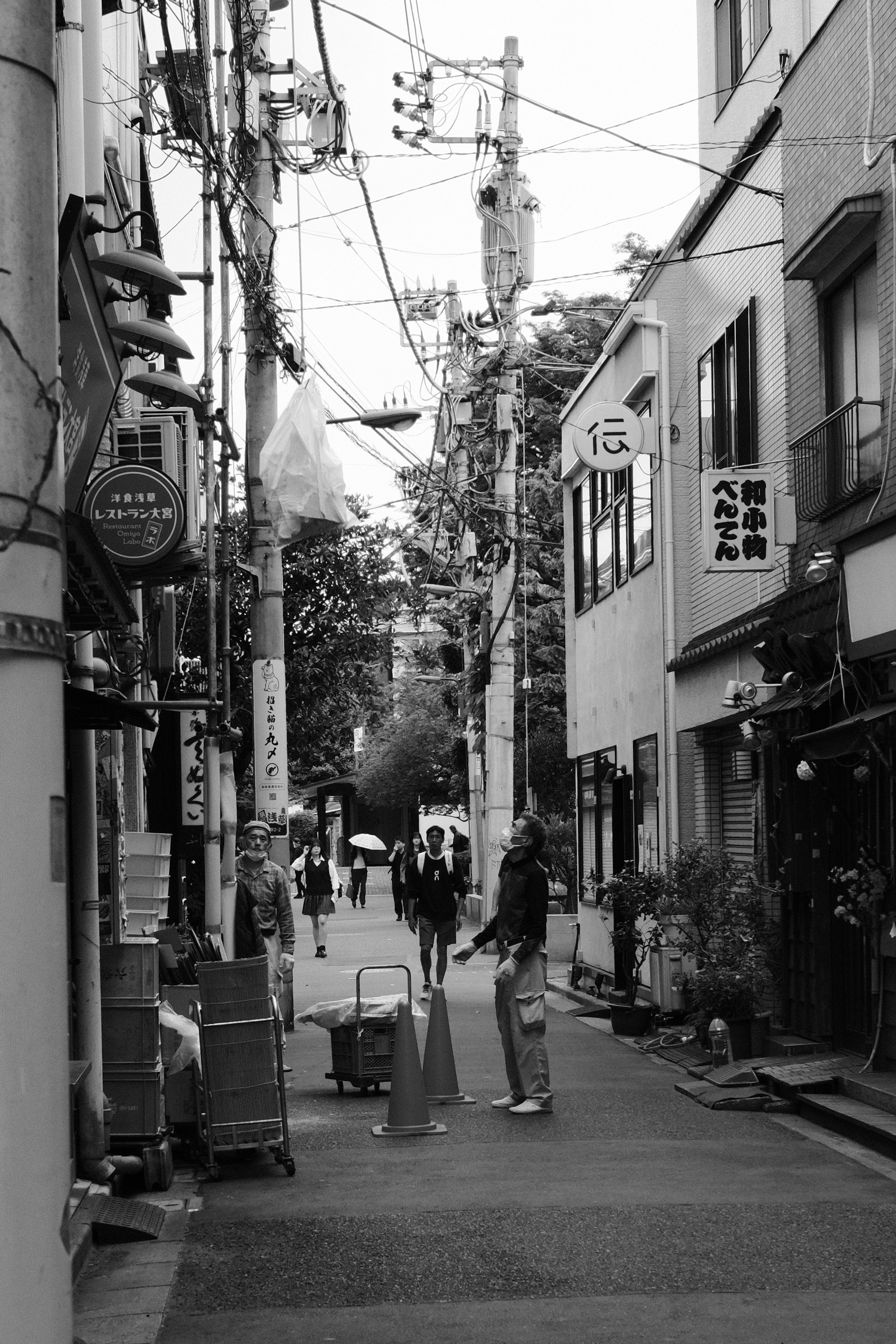 Narrow Alleyway Pulse: Street Life Under Monochrome Skies
