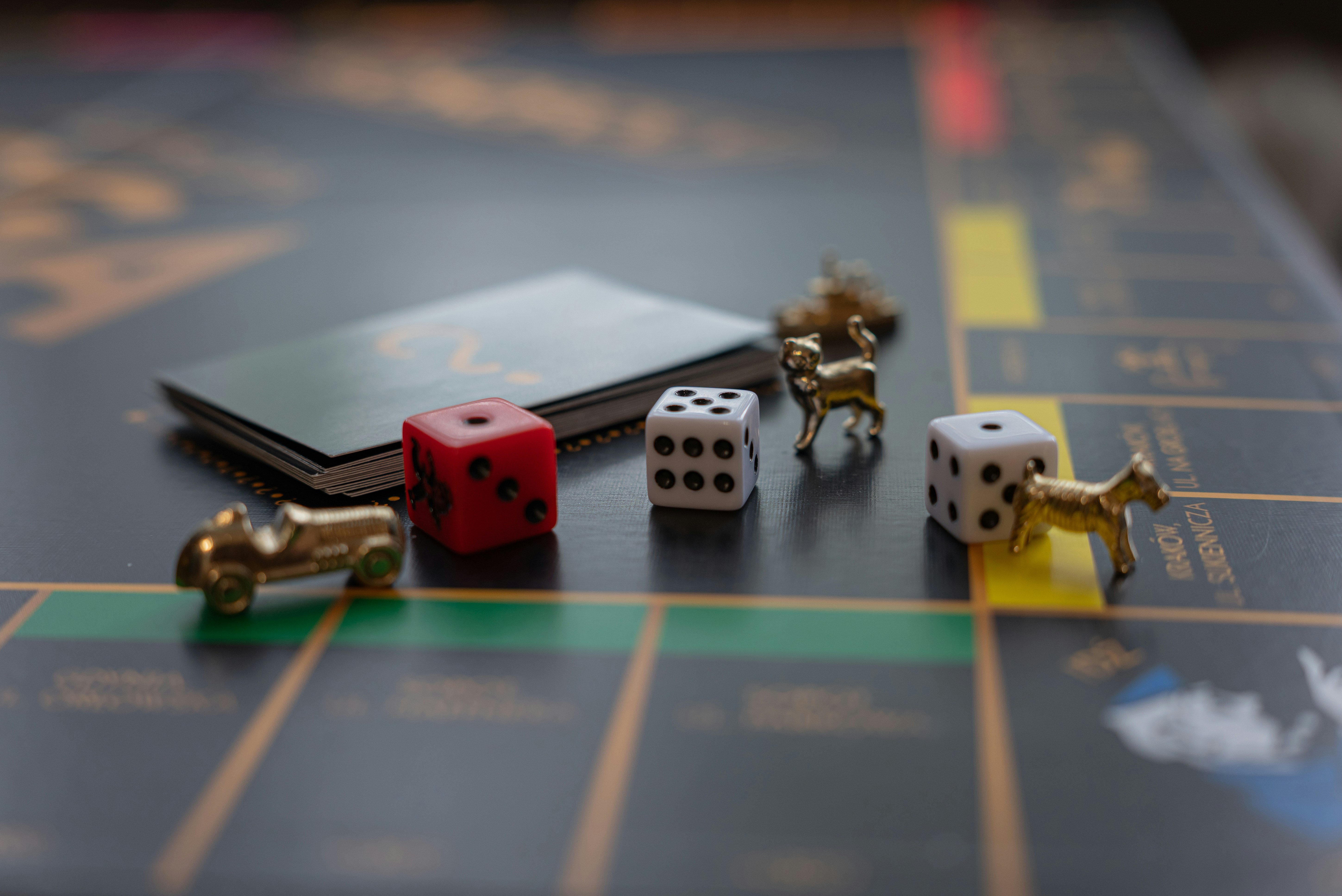 Dice and miniature figures on a casino-themed game mat, softly blurred in a tilt-shift scene