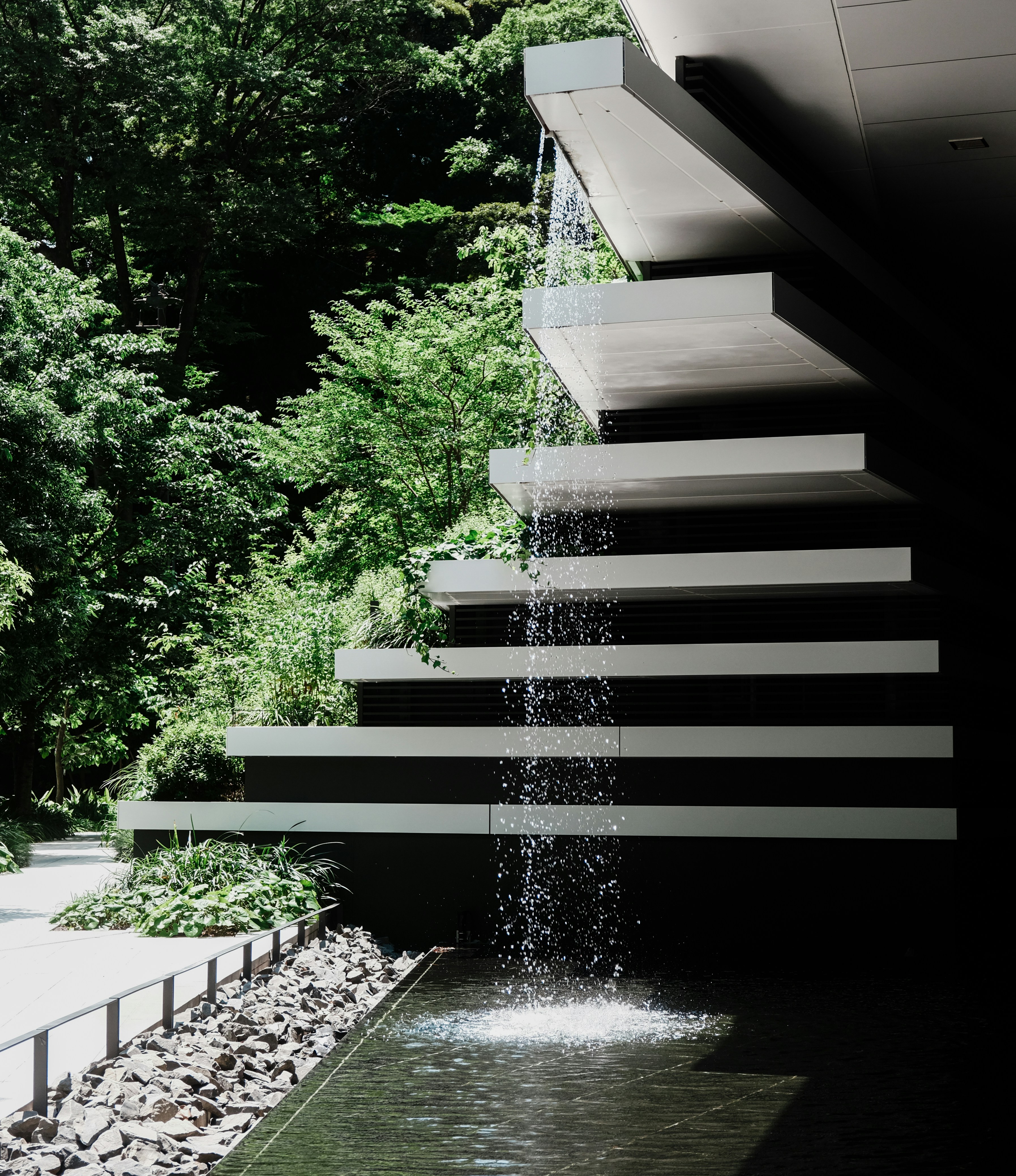 Stepped Waterfall Cascade Against a Modern Architectural Overhang