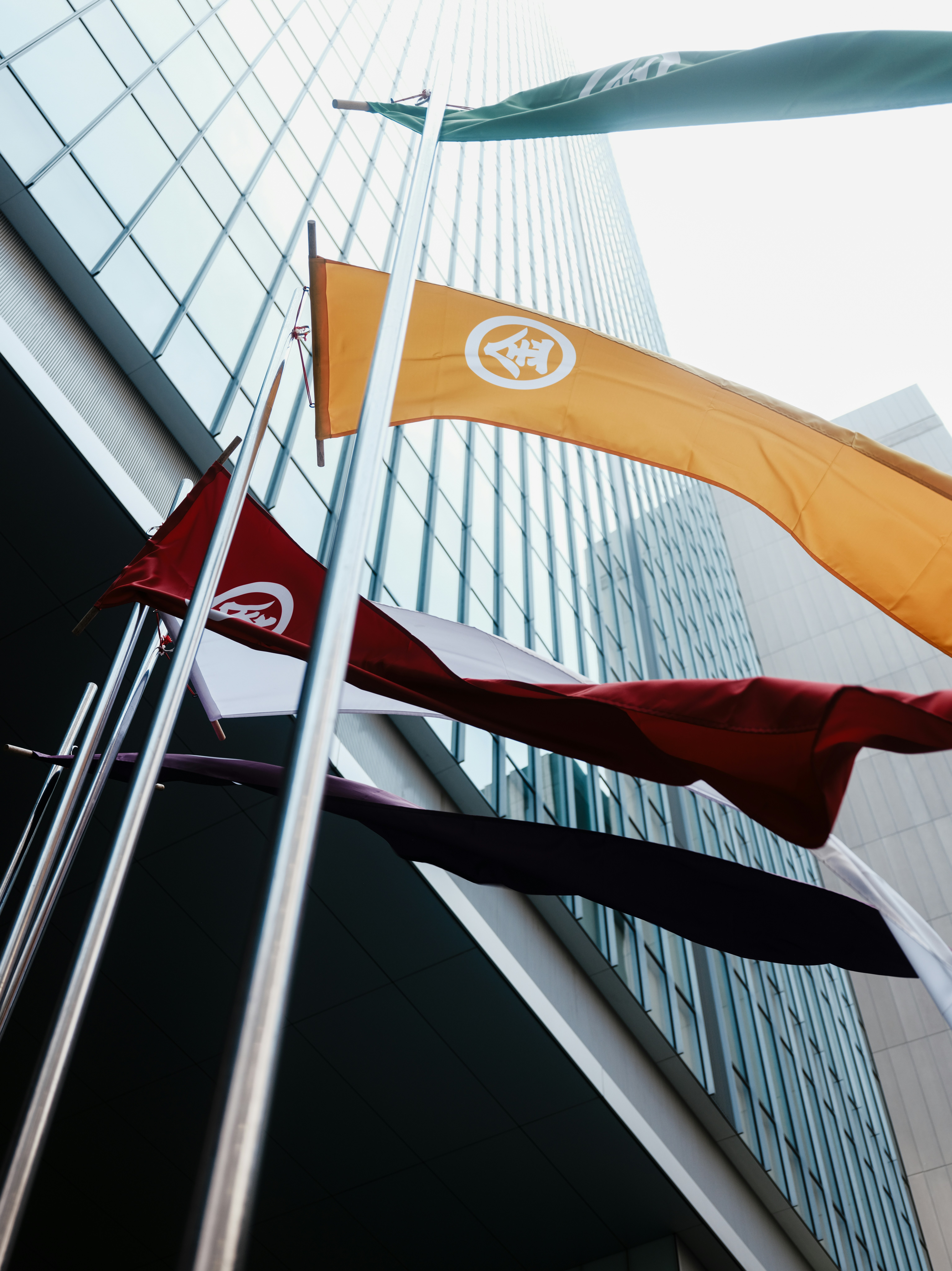 Curved banners against glass towers rise toward the sky