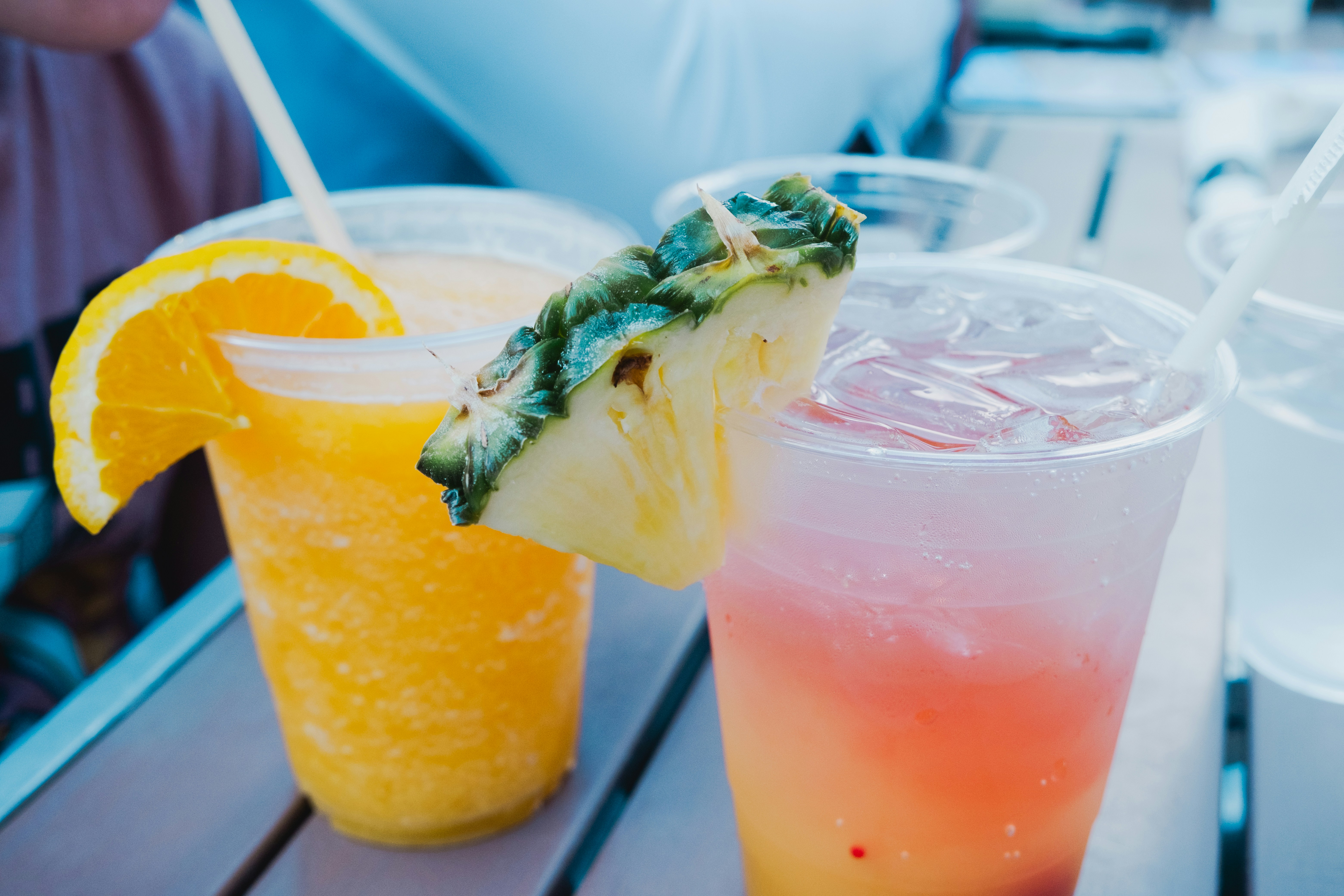 Two colorful tropical drinks with fruit garnishes on a table. photo ...
