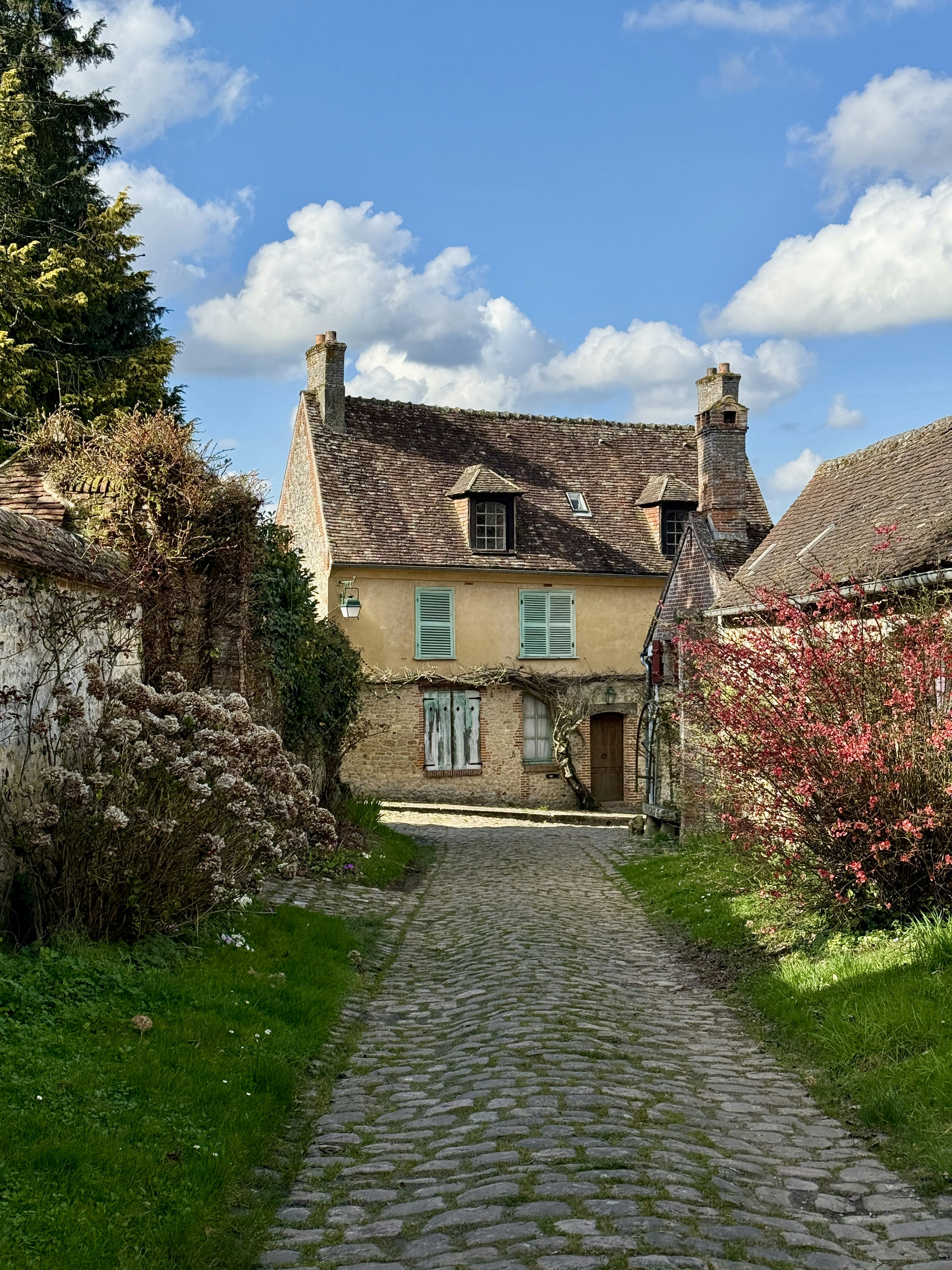 Cobbled Lane Toward a Cottaged Courtyard
