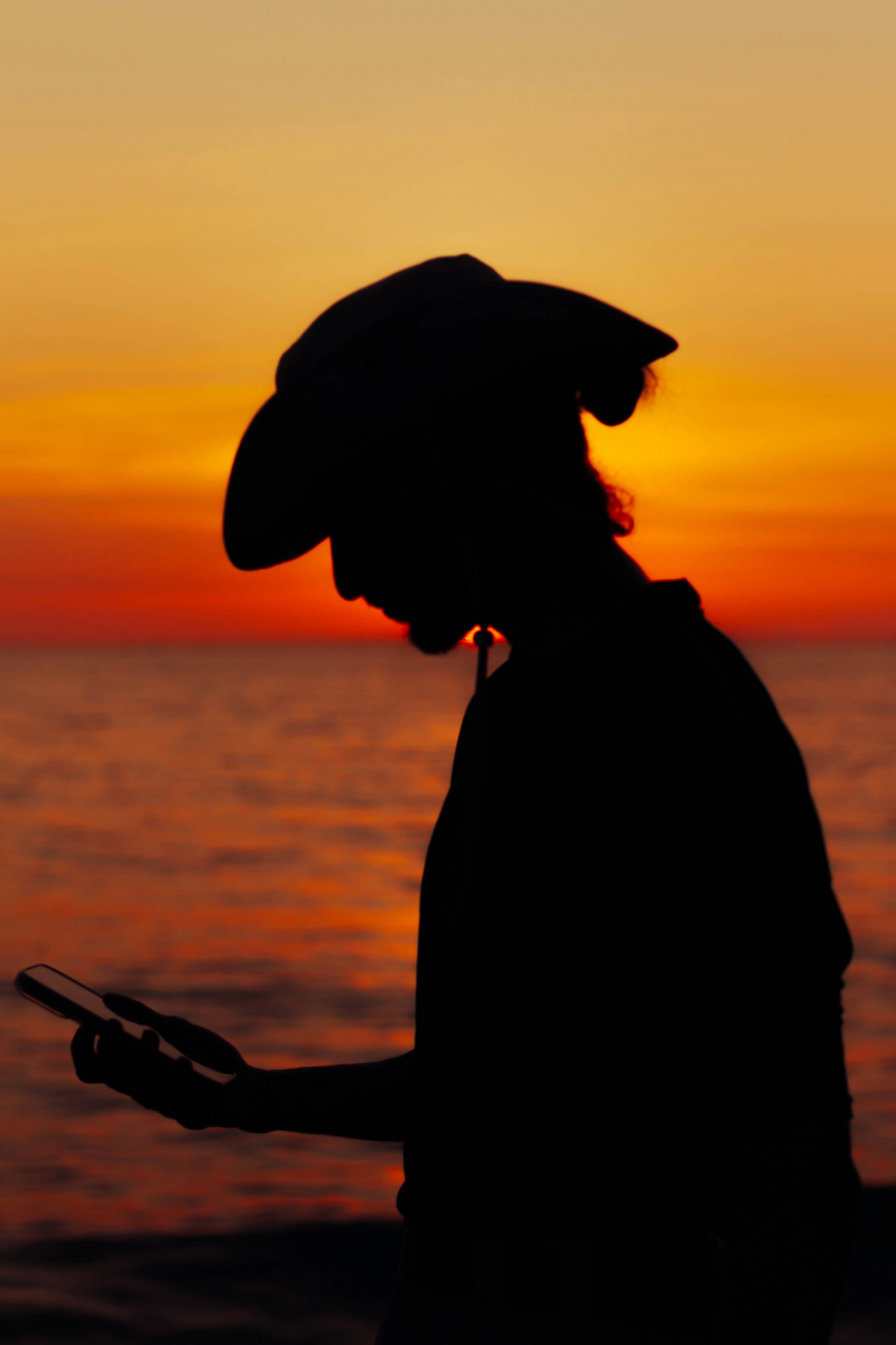 Silhouette at Sunset: A Quiet Moment with a Phone