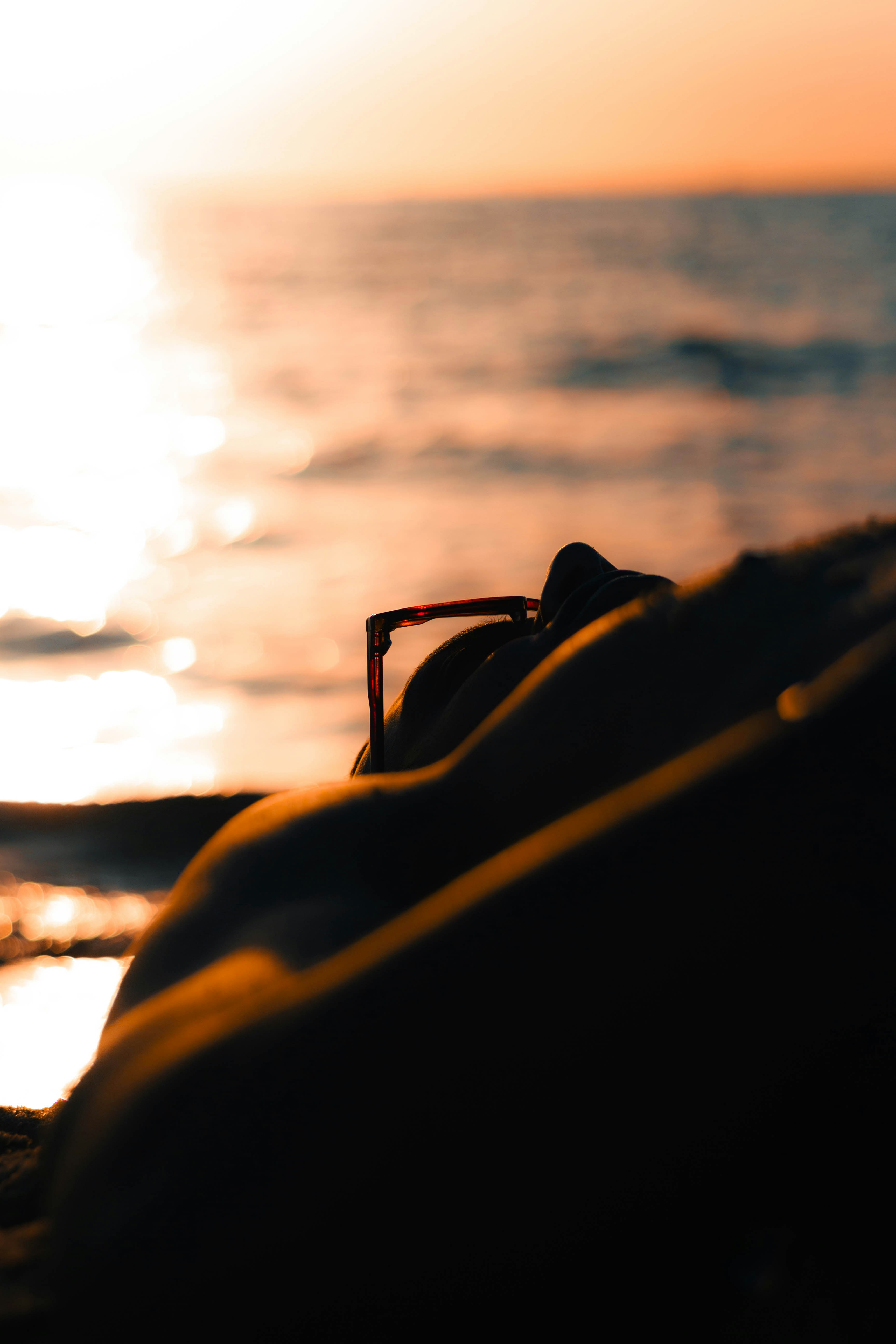 Sunset Silhouette: Glasses Half-Submerged in Dusk at the Waterline