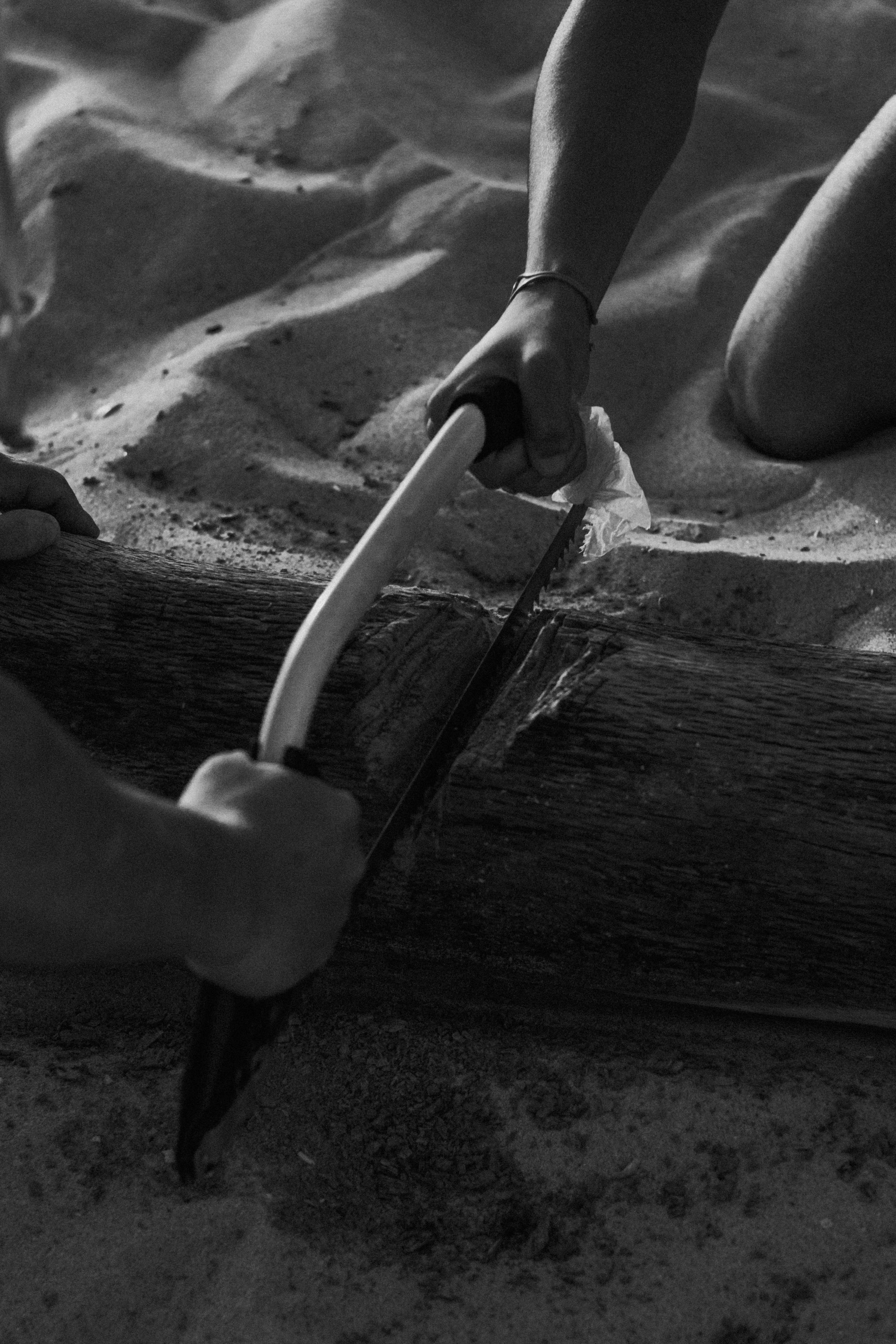 Carving with Focus: A Hands-On Moment in the Sand and Wood