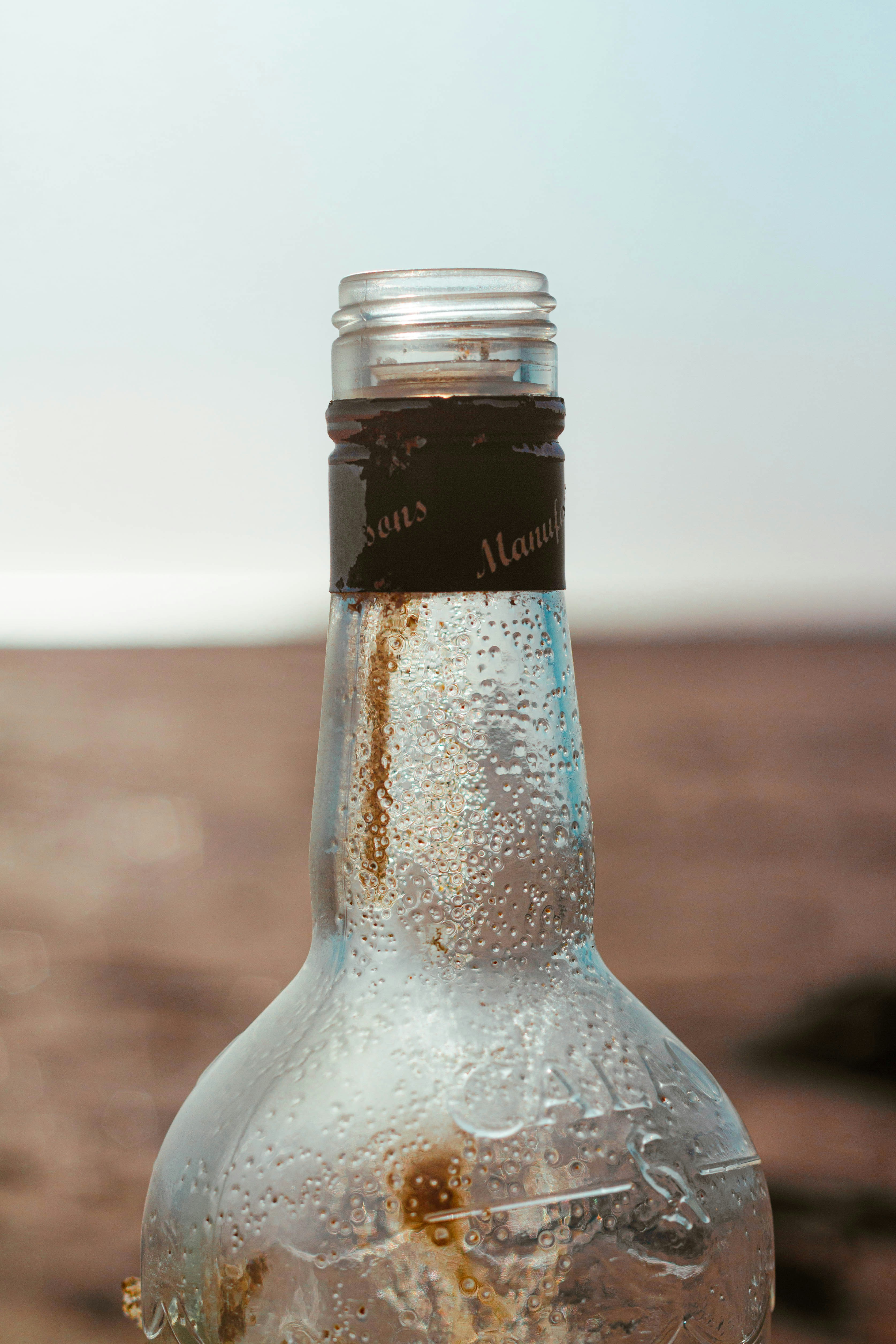 A bottle with condensation, caught in soft sunset hues