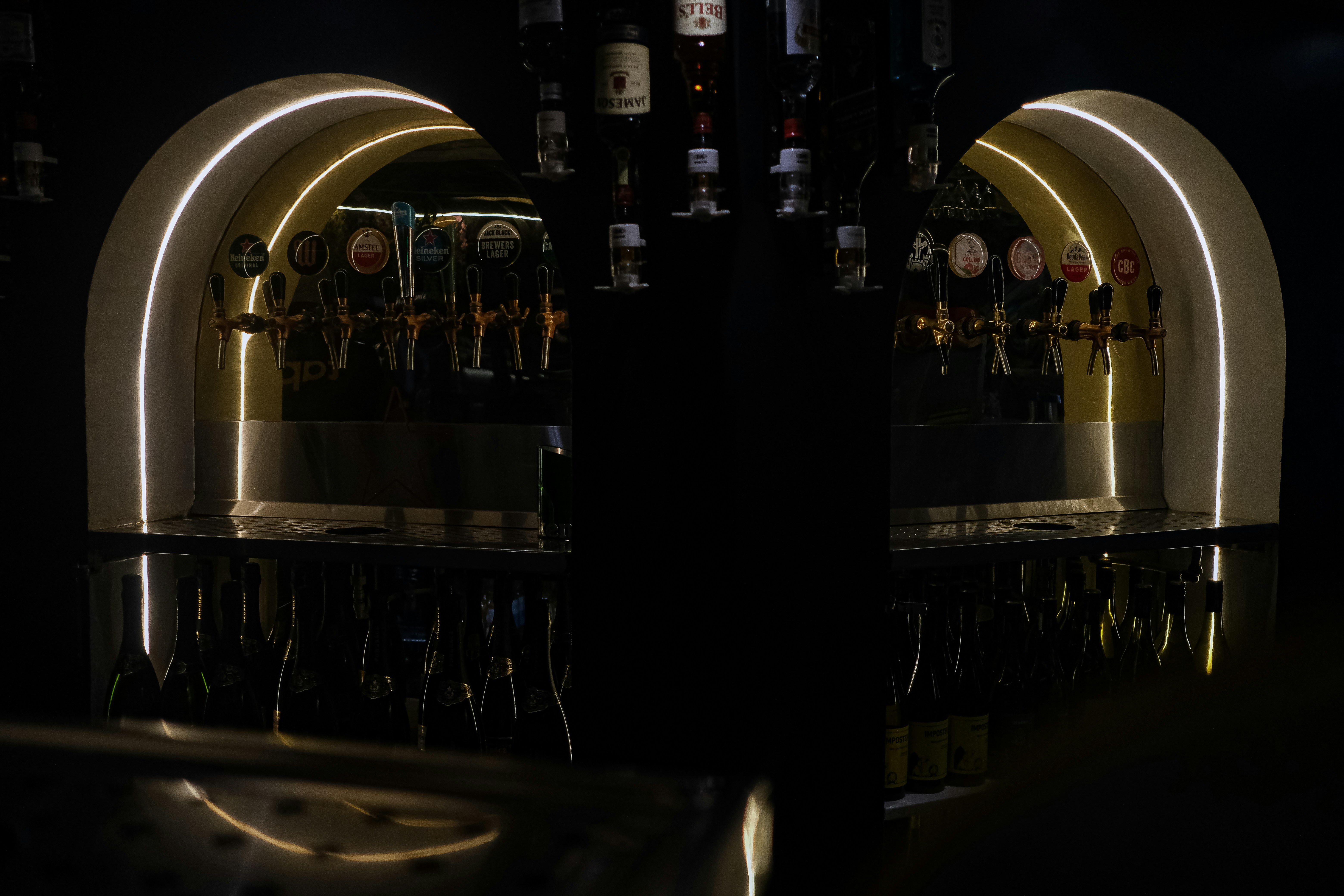 Symmetrical Neon Arch Reflections in a Dim Bar