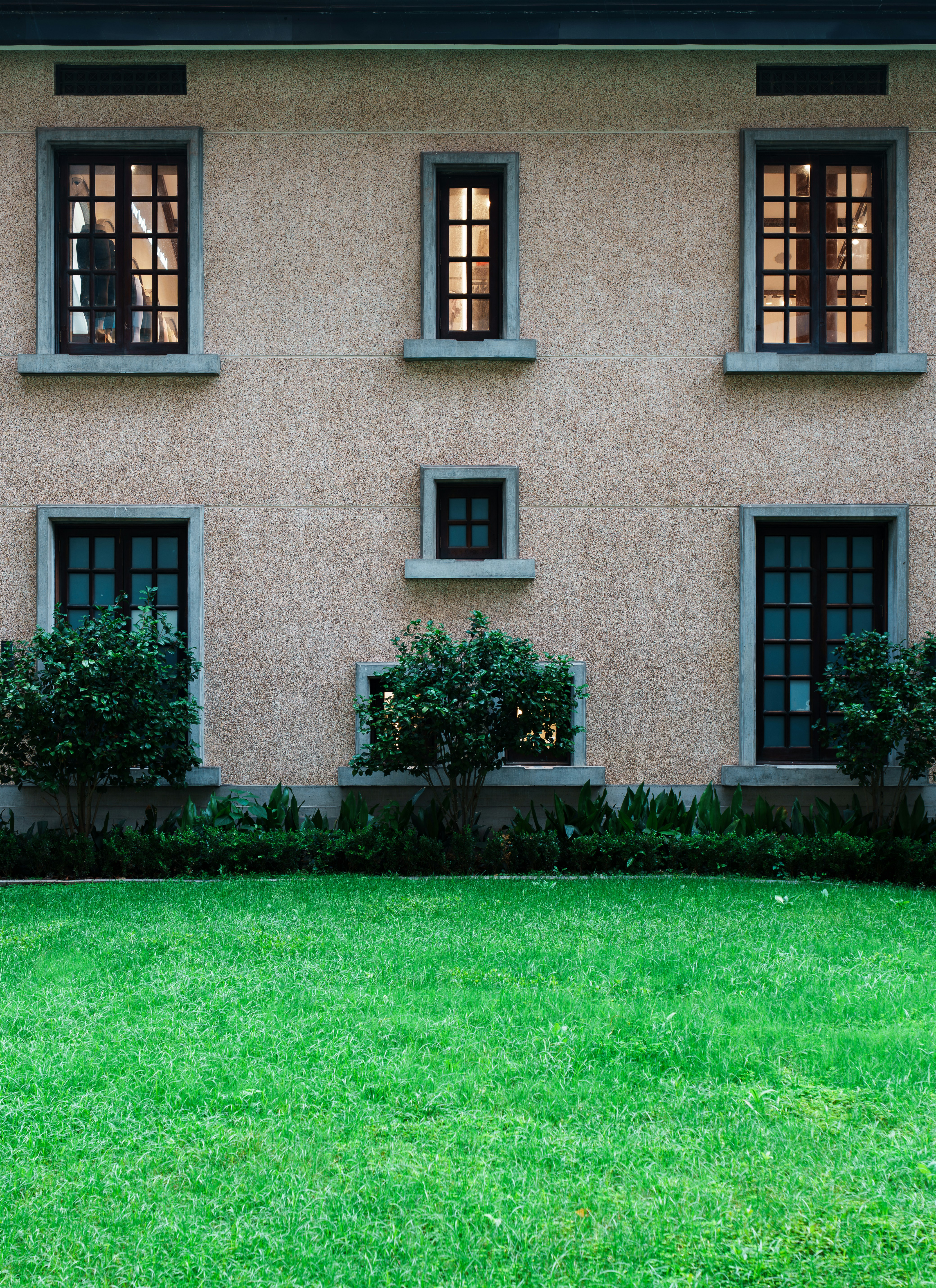 Symmetrical Facade: Moonlit Windows and Green Terrace