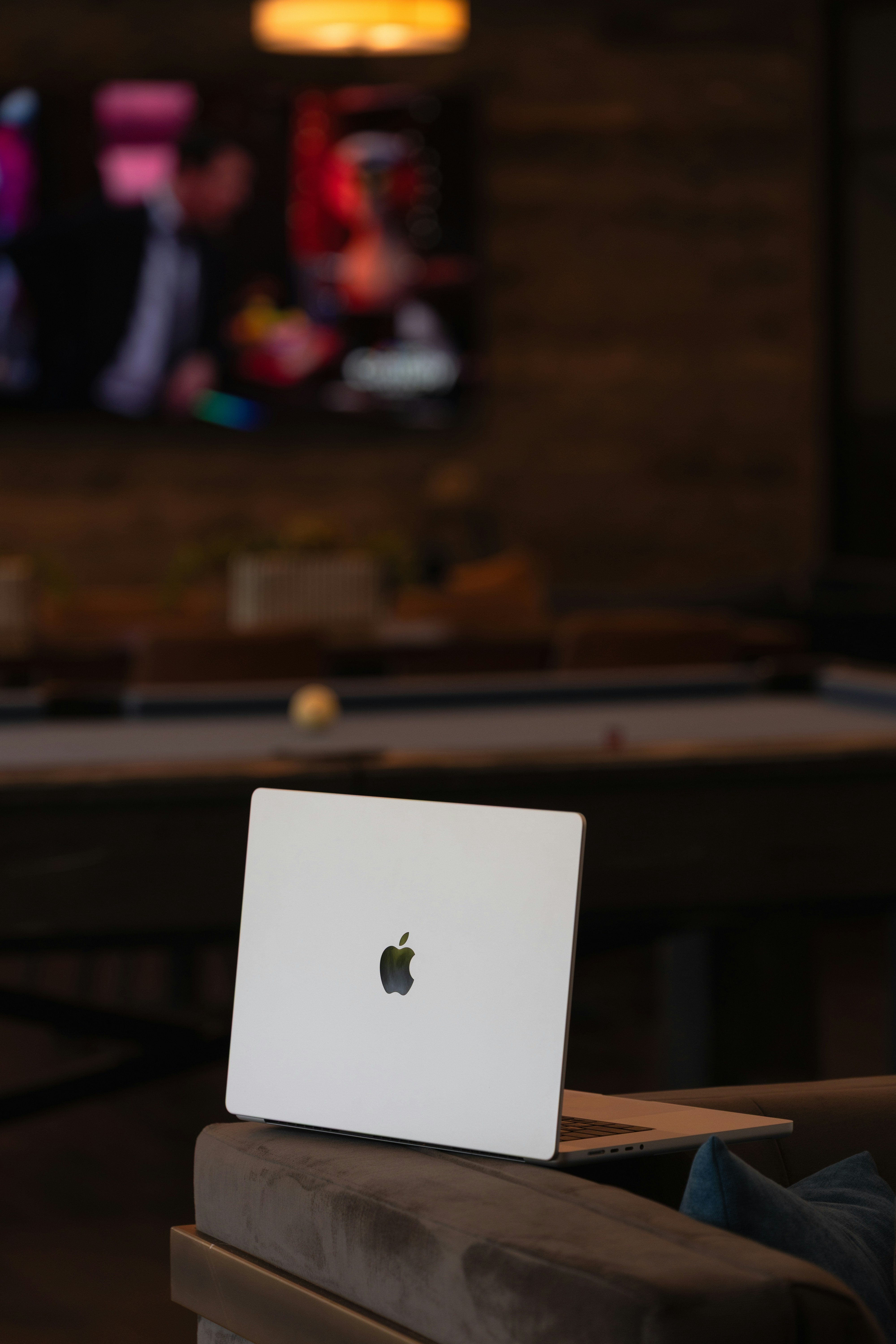 Apple on the Stage: A Quiet Laptop Amid the Bar Counter Glow