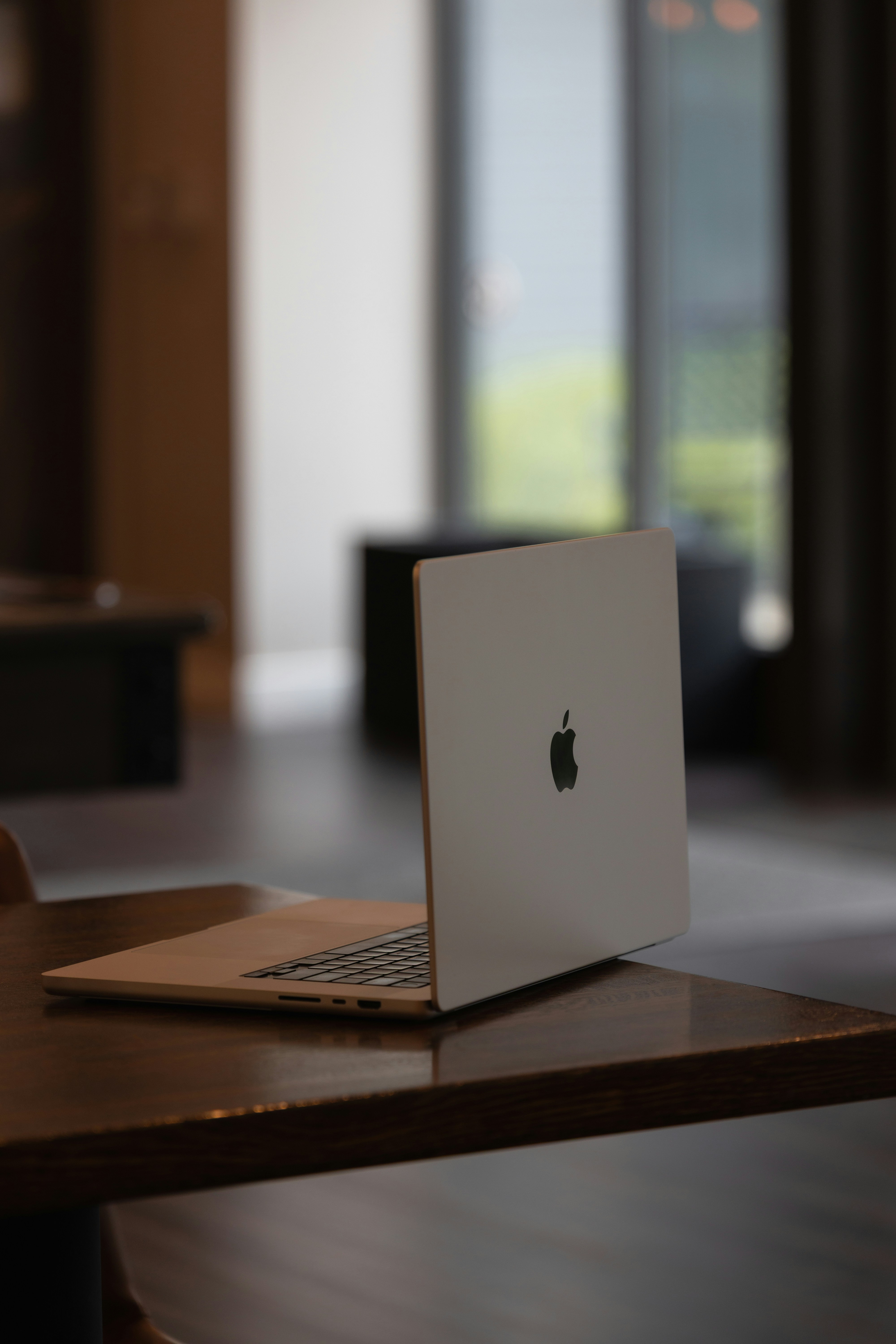 Apple MacBook on a Wooden Table in a Quiet Lobby