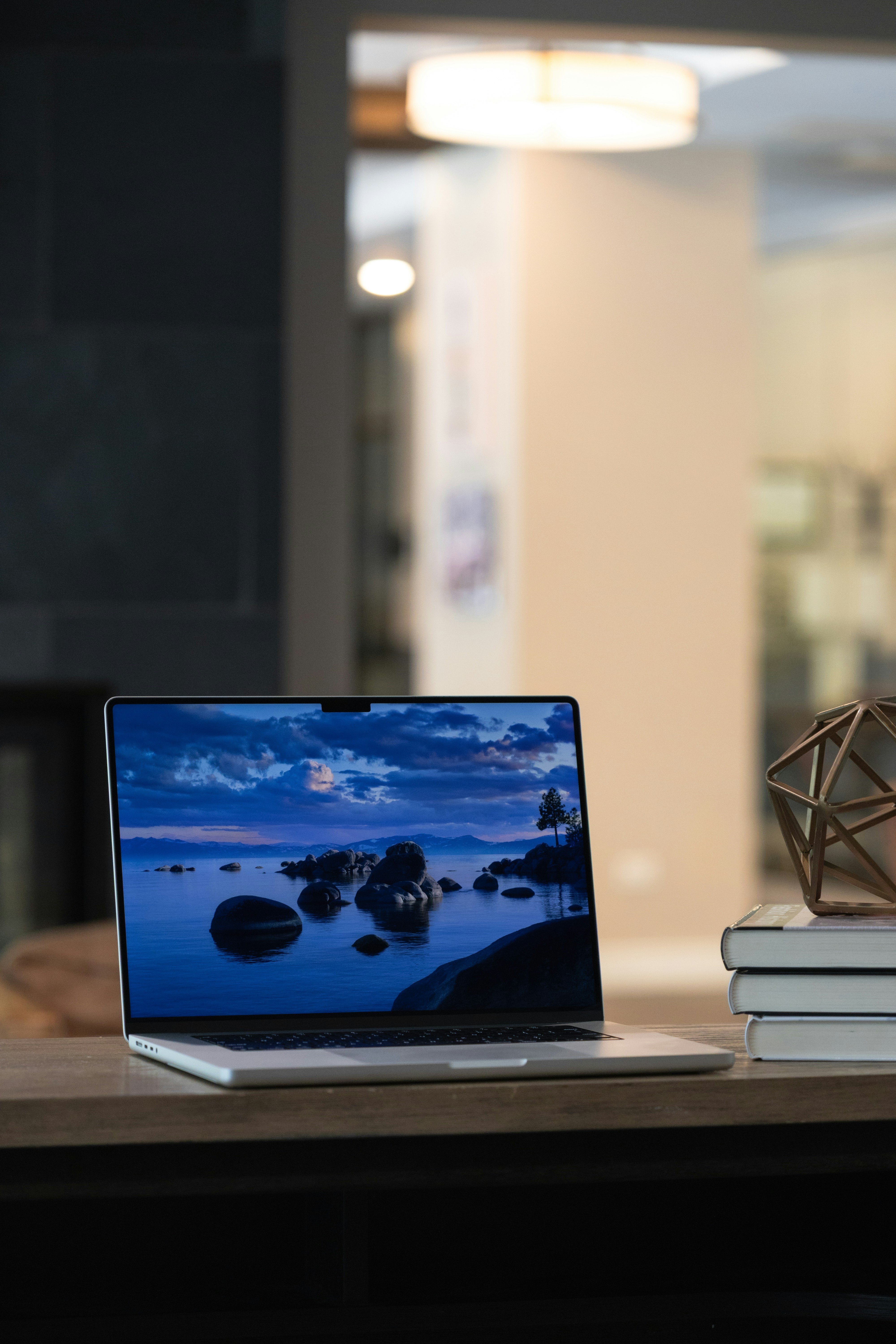 Cozy workspace centerpiece: laptop with rocky seascape on screen