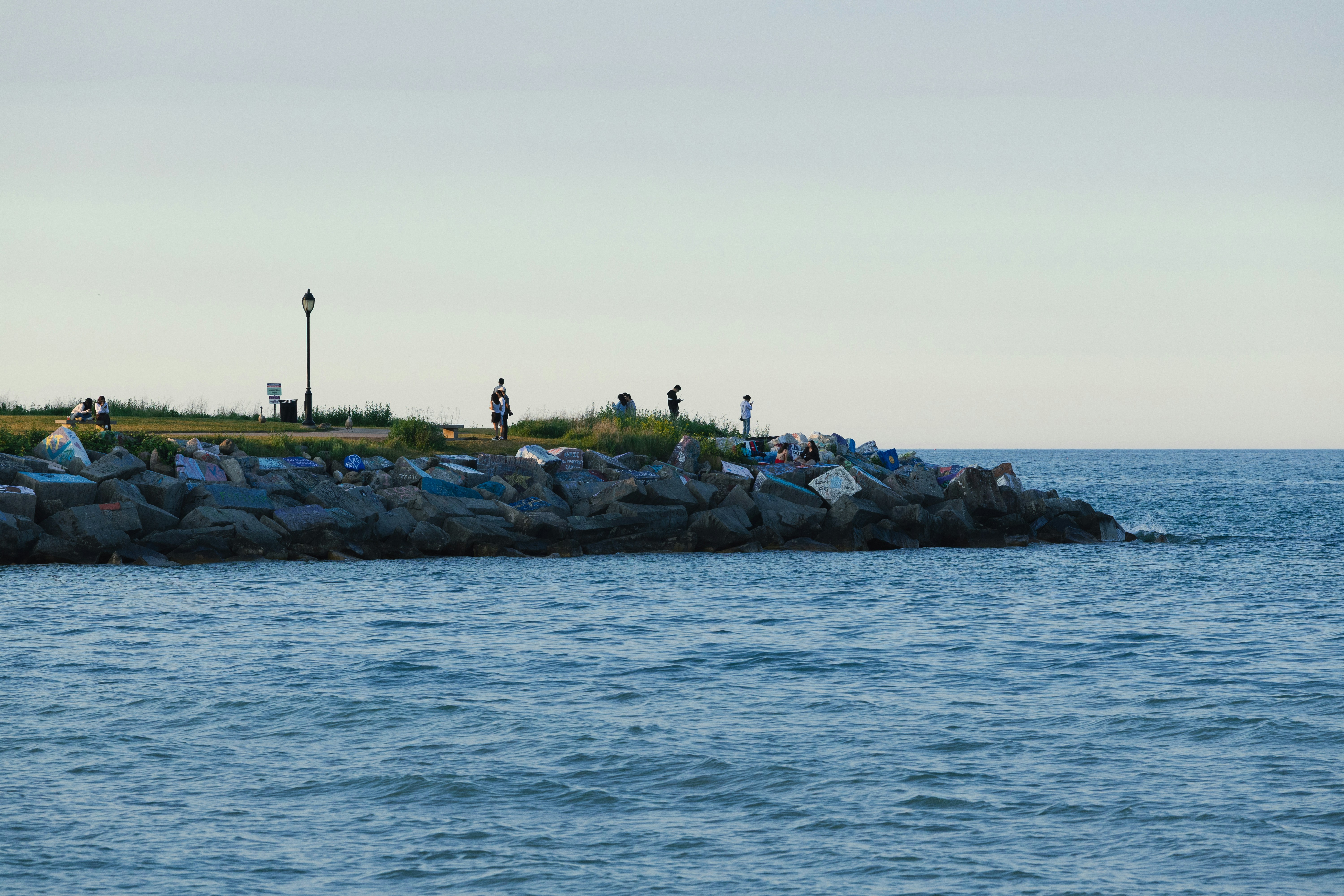 People at the Breakwater: Quiet Line Along the Sea