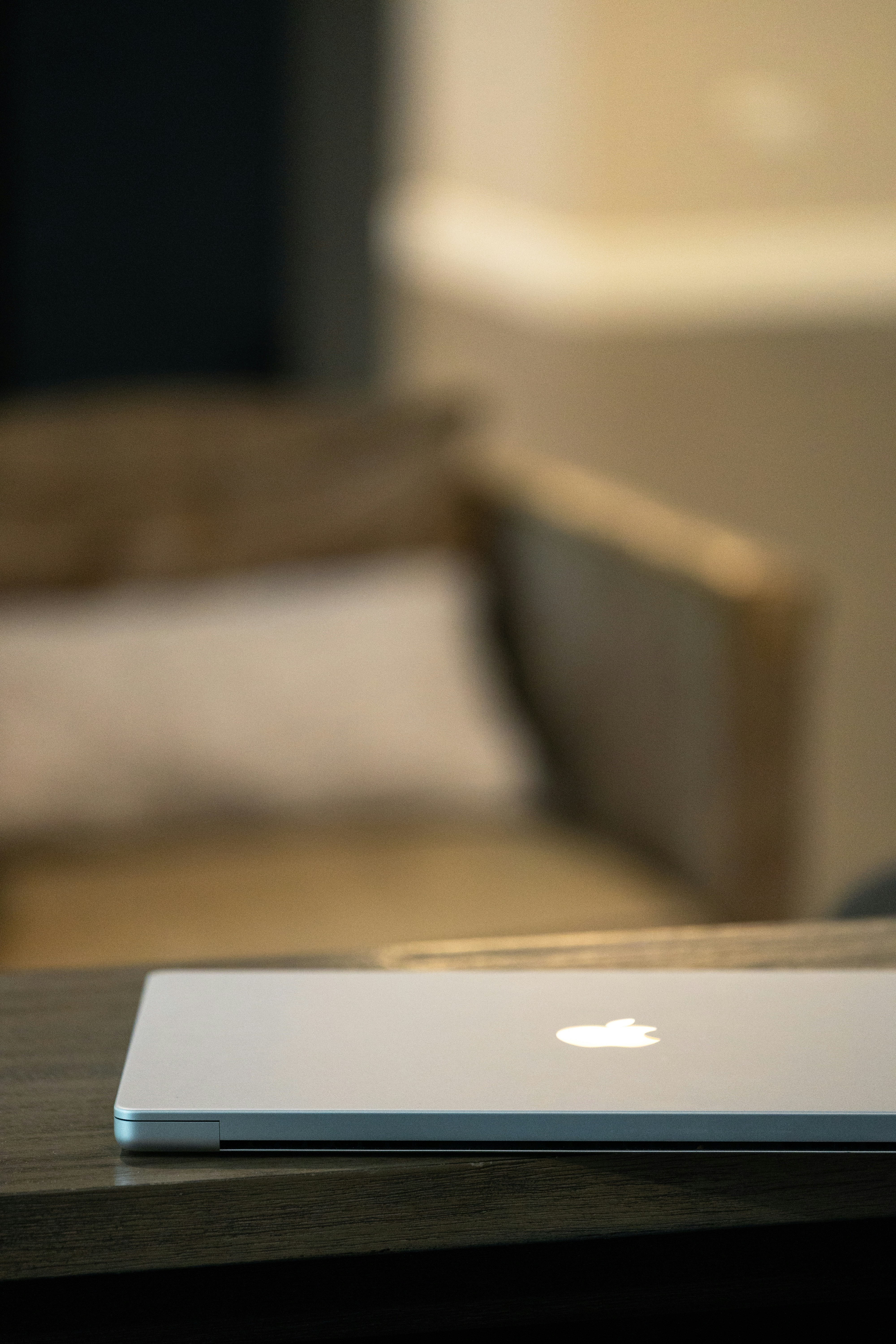 Silenced Workspace: A MacBook Quietly Resting on Wood