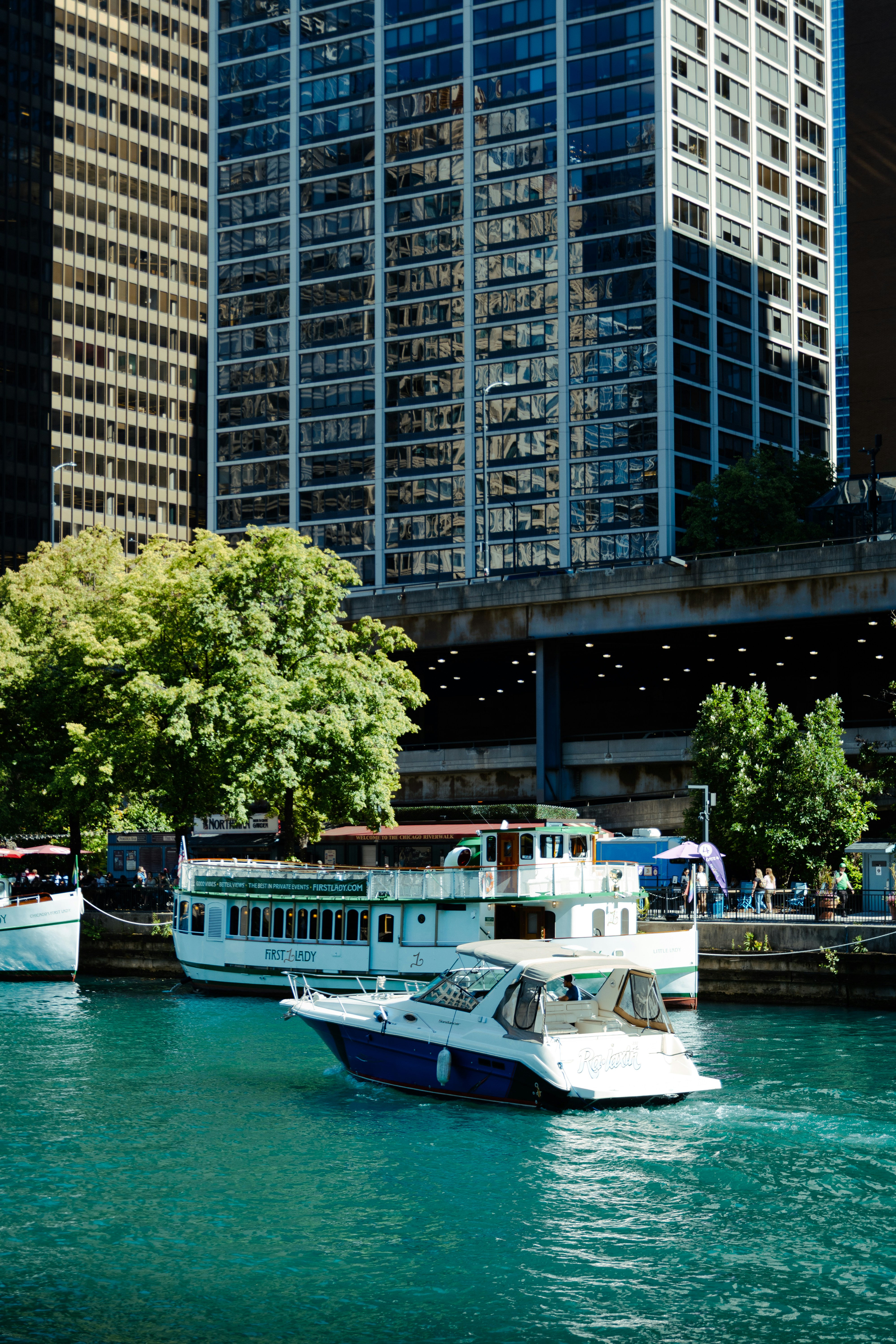 Riverfront Parade: Boats at the Base of a Glass Facade