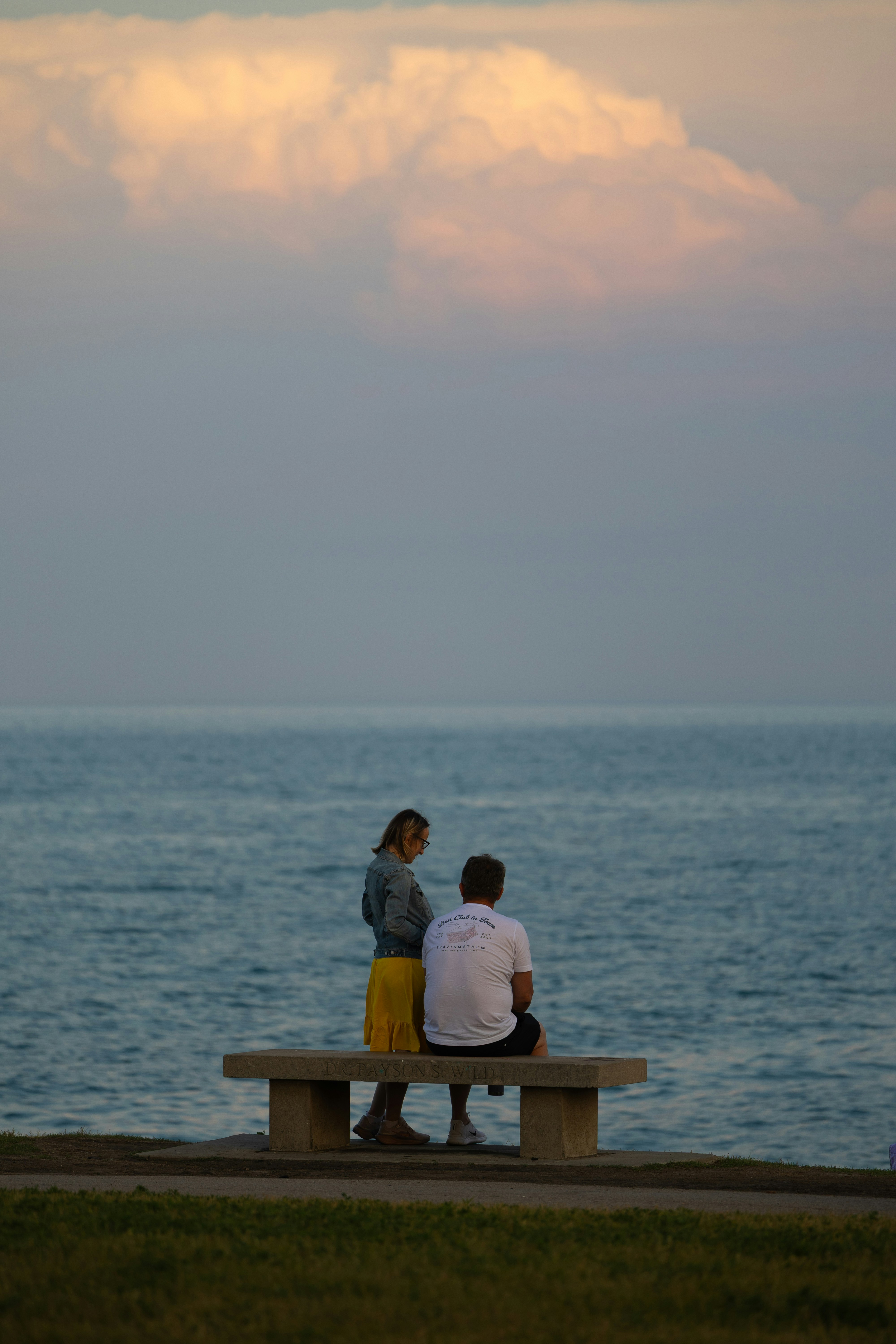 Quiet Conversation on a Seaside Bench at Dusk