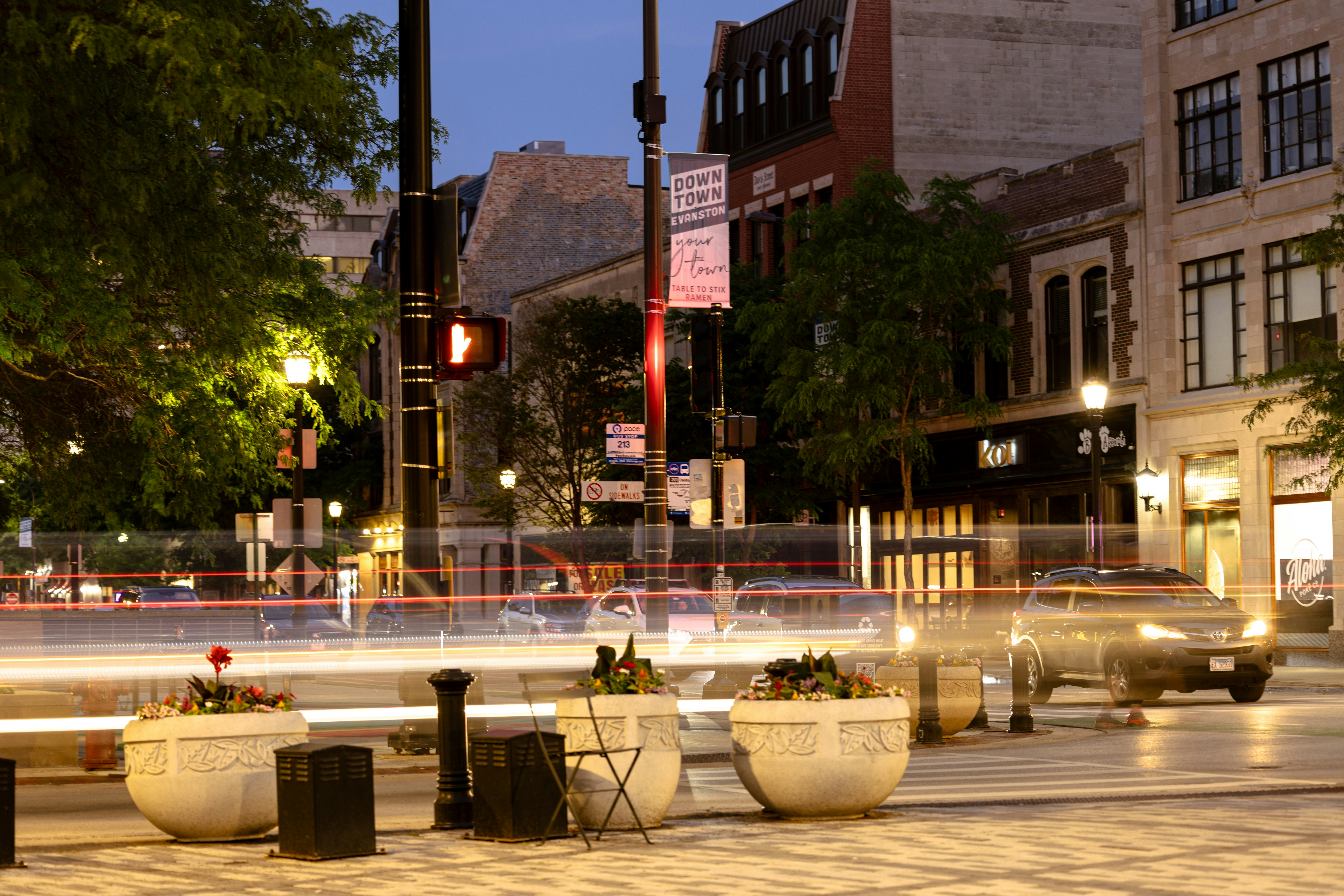 Nighttime Street Ballet: Light Trails and Quiet Tables