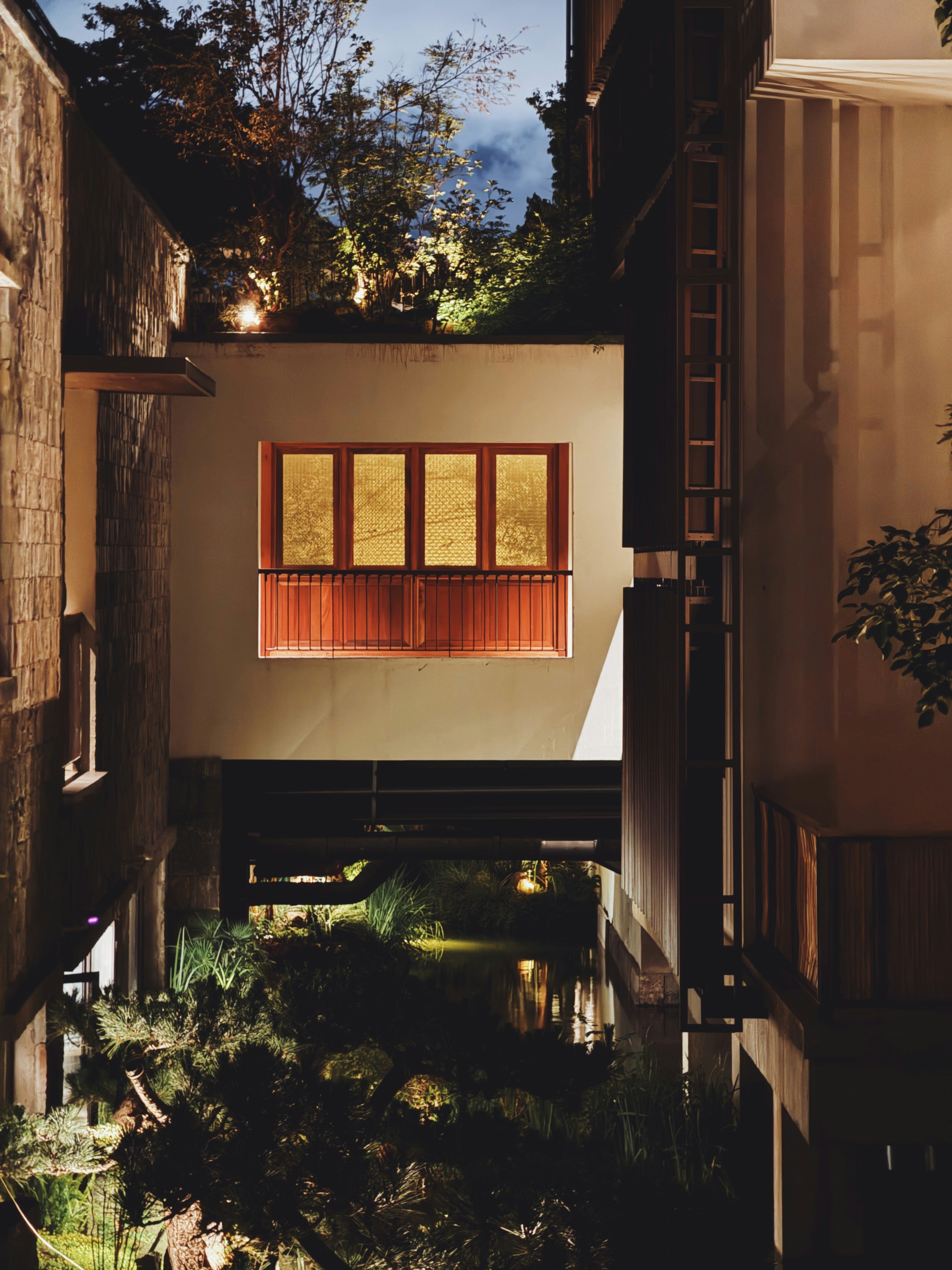 Night bridgehouse: warm window as beacon over tranquil canal