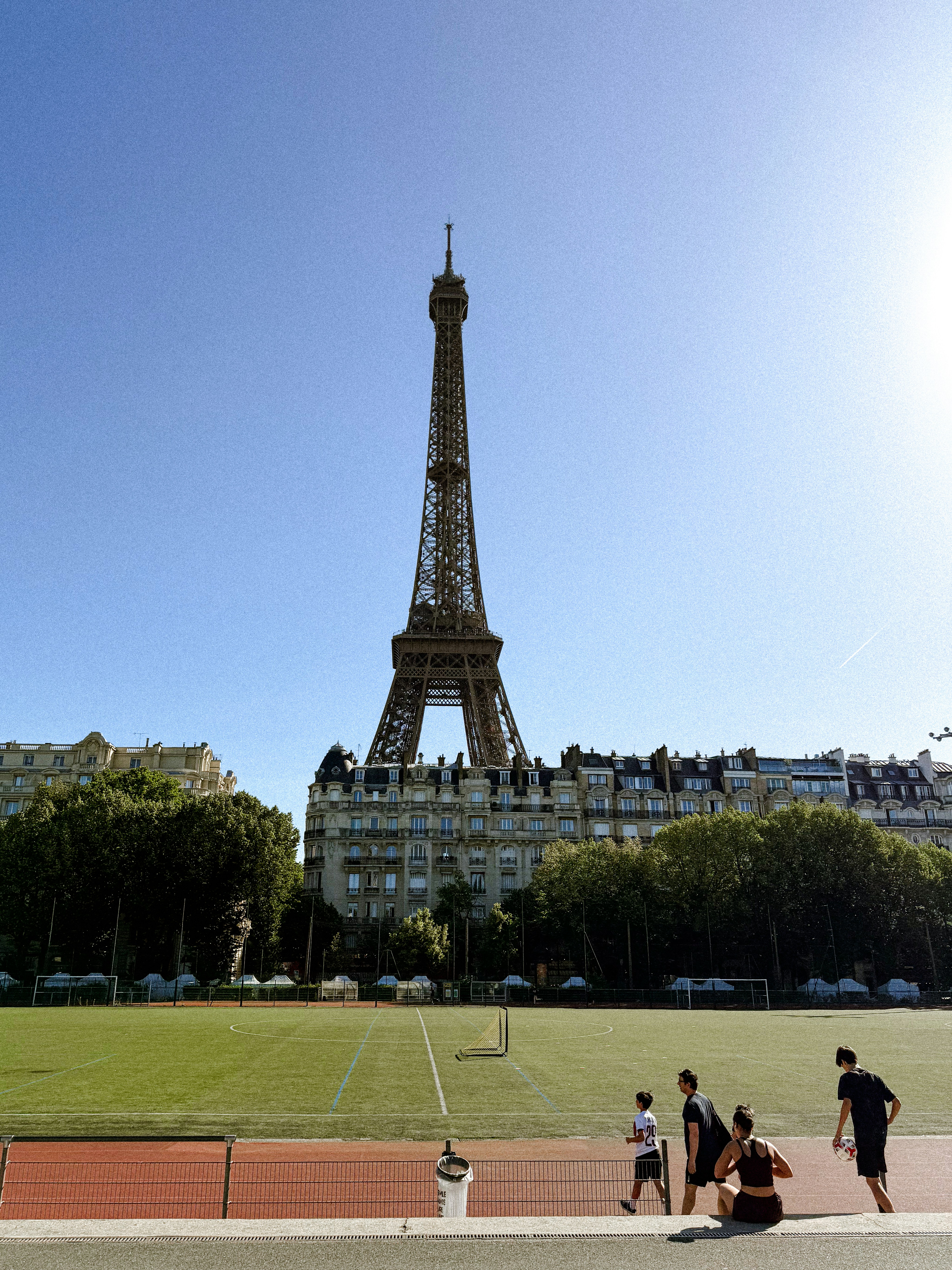 Eiffel Tower Silhouette Beyond a Sunny Parisian Field