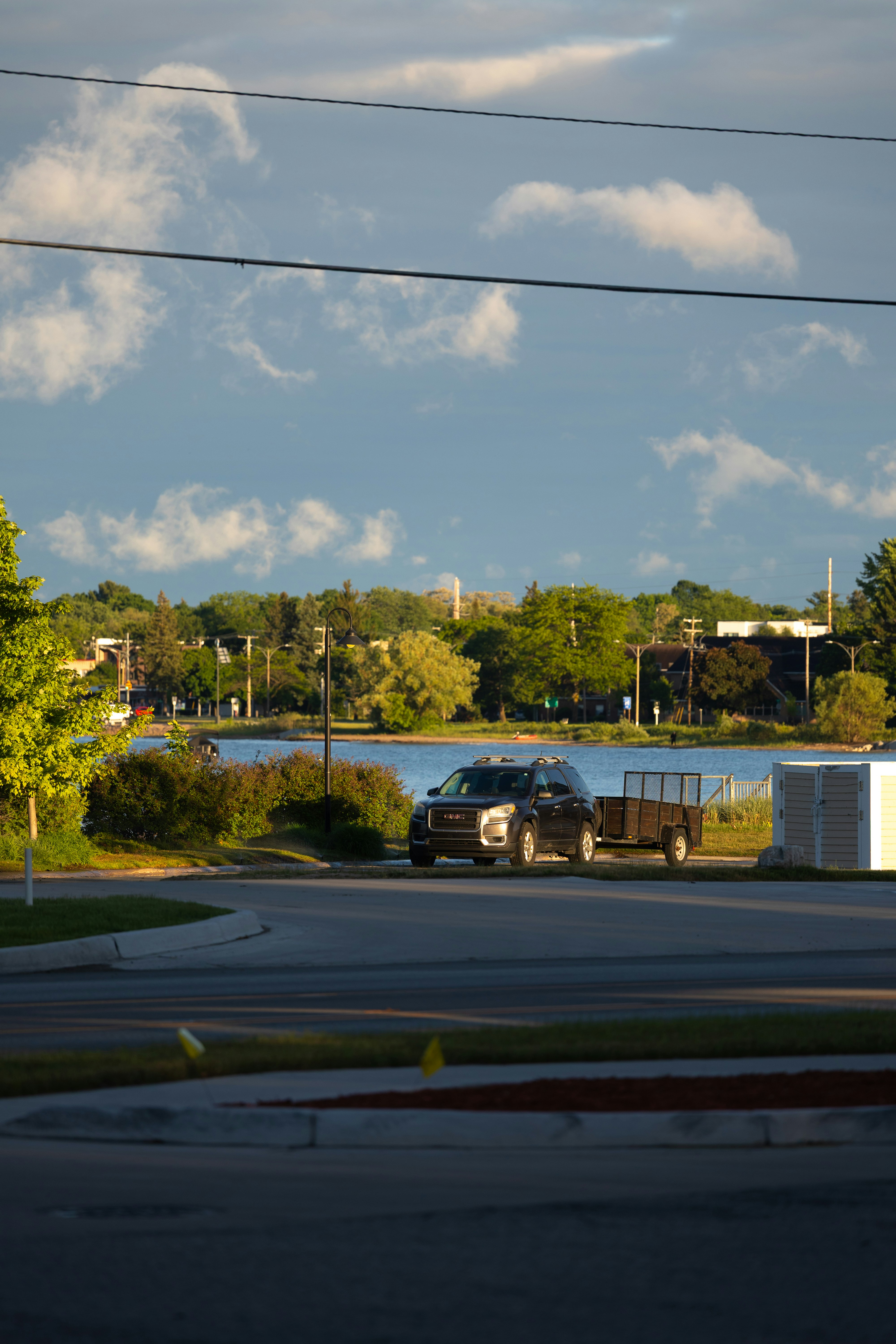 Midday Drive by the Water: A Truck and Trailer Quietly Sit by the Shore
