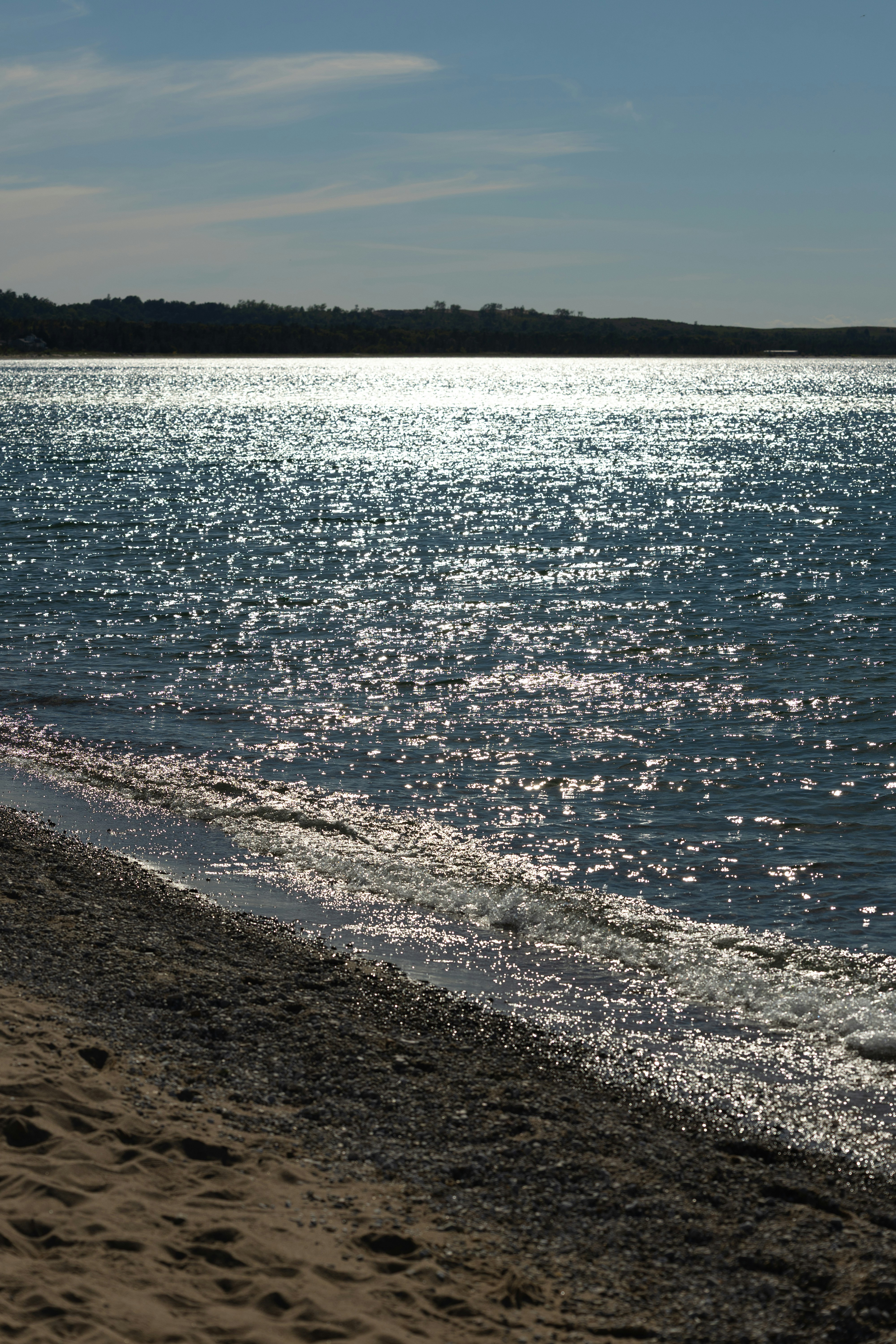 Sunlit Shoreline: Sparkling Waves along a Quiet Beach