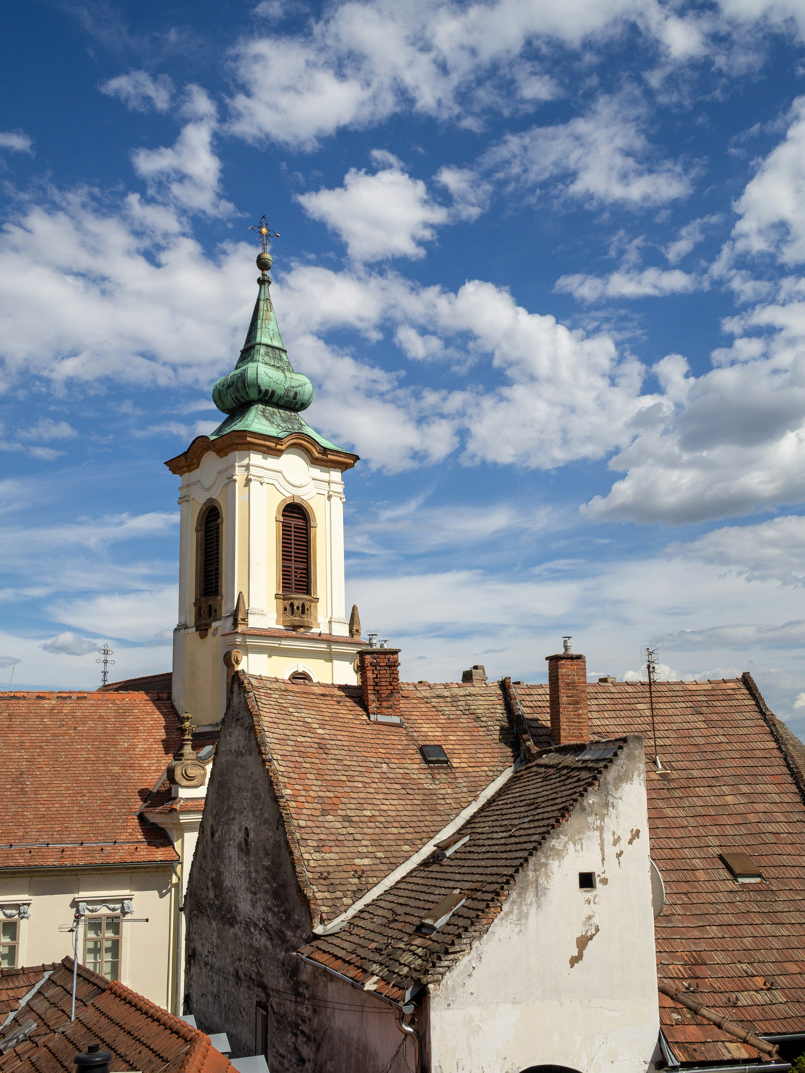 Turreted Celestial: Rooftops and Clock Tower Under a Shallow Sky