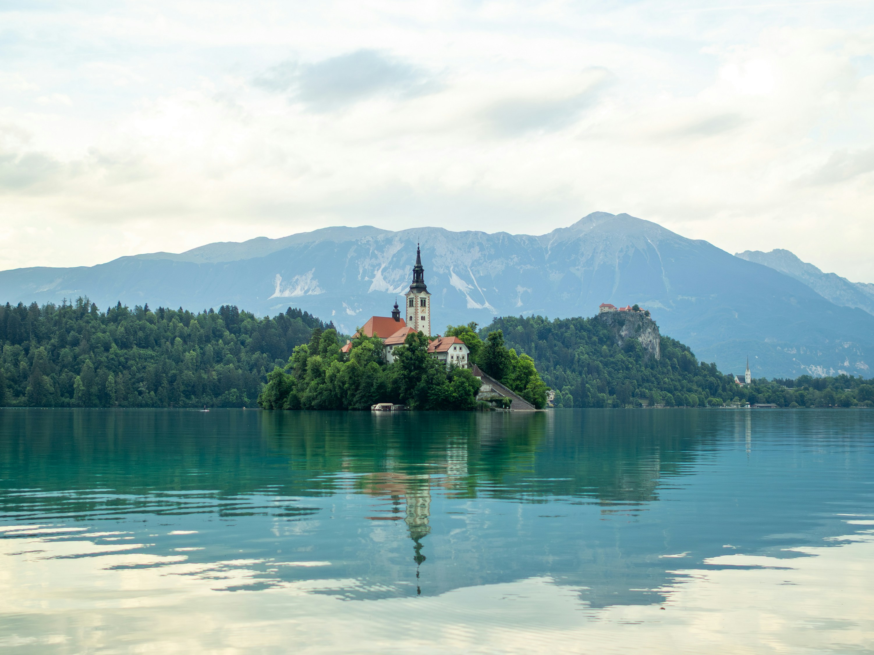 Independent Island Chapel Emerging from a Serene Alpine Lake