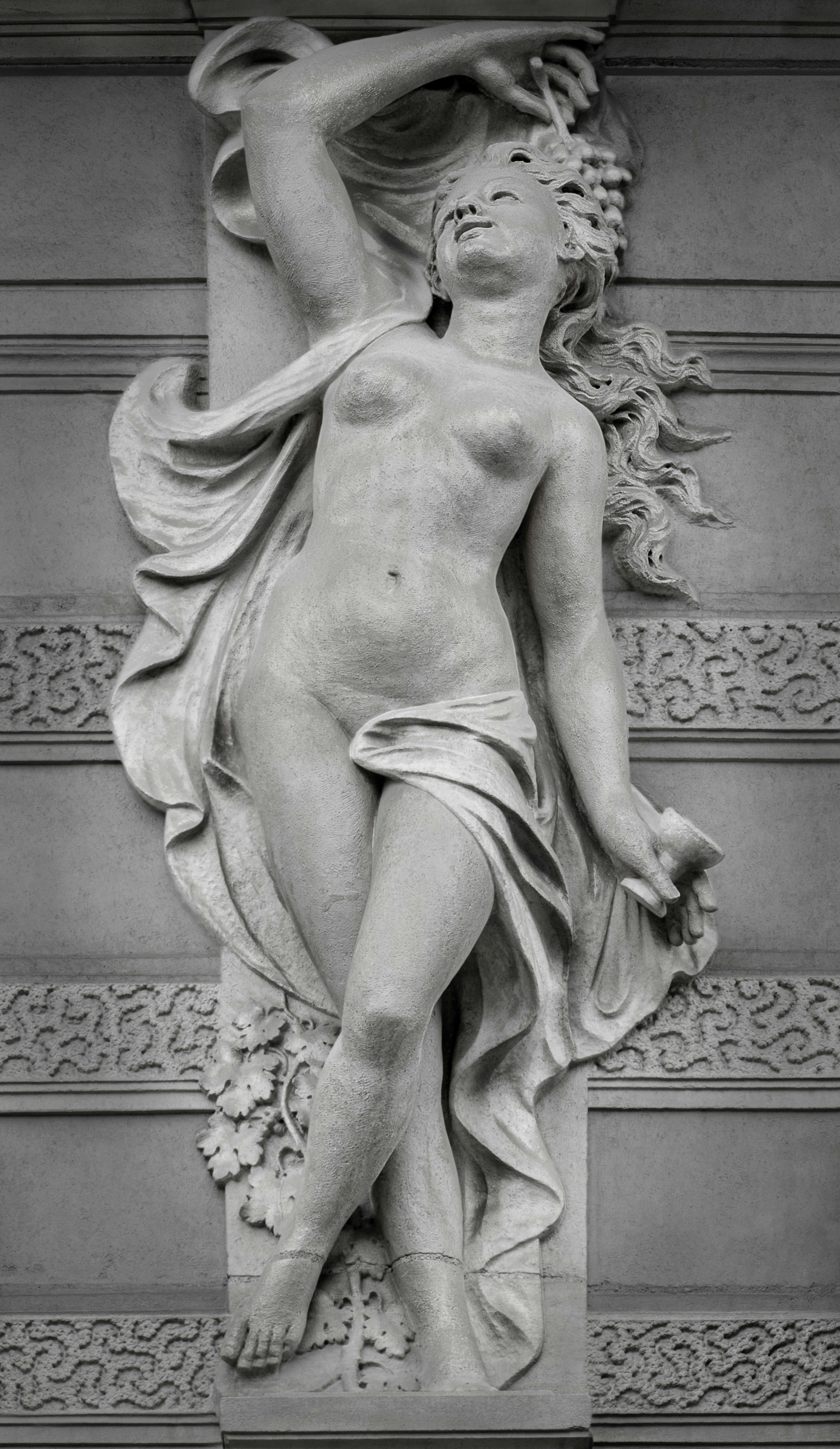 Stone Muse: A Classical Statue Reaching Toward Light