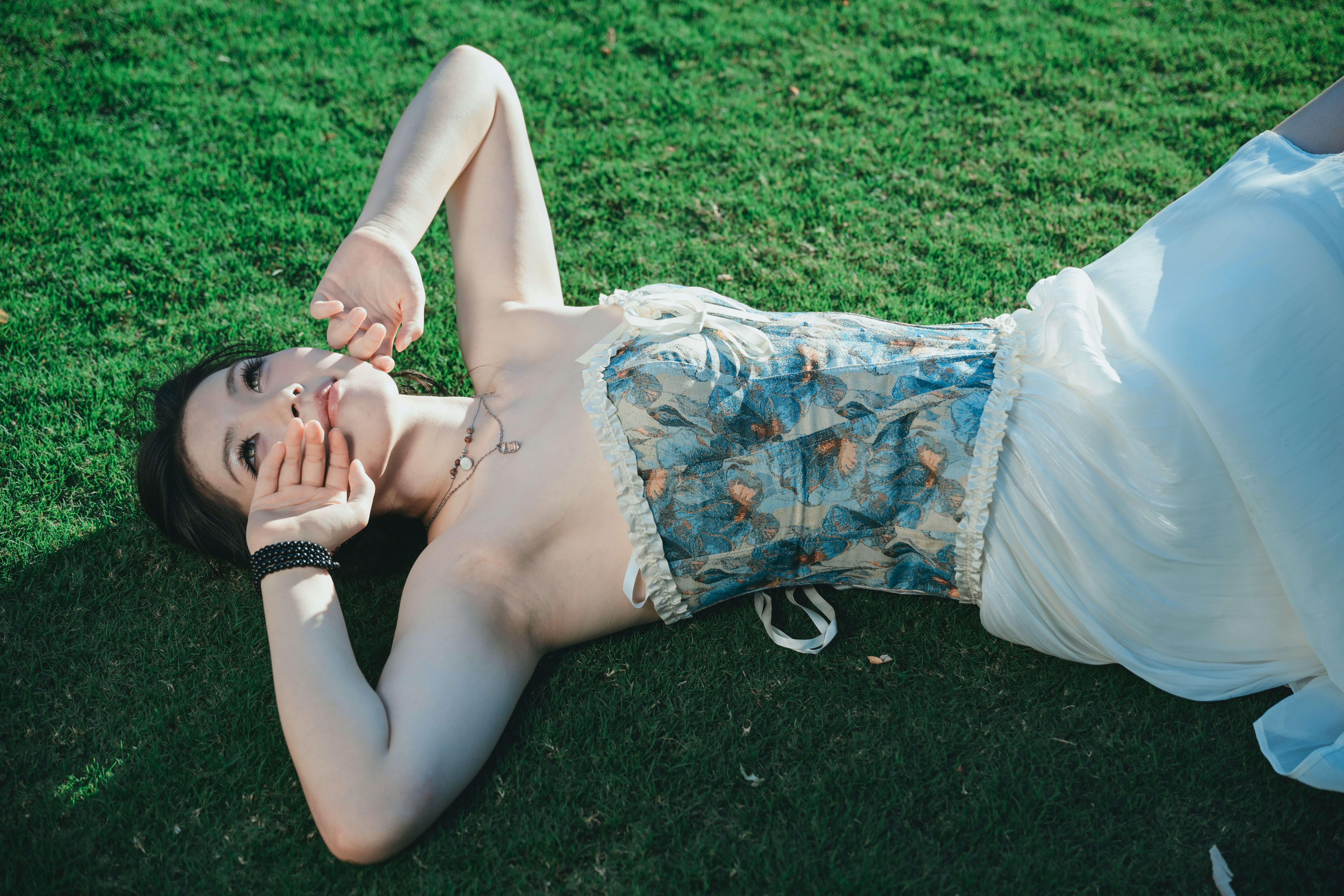 Relaxed portrait on turf: a sunlit moment in a corseted dress
