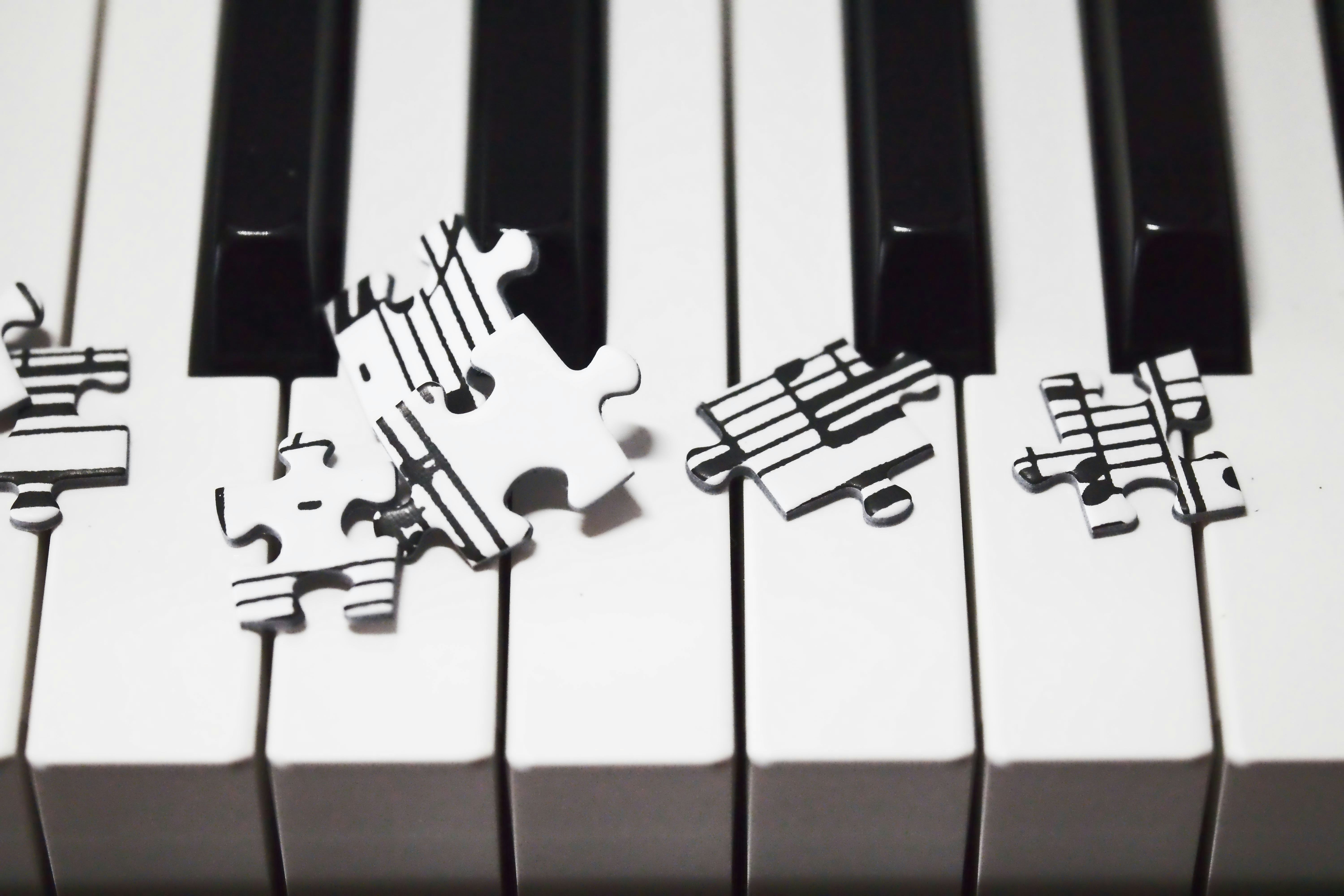 Broken chords on white keys: scattered jigsaw pieces hint at unfinished melodies
