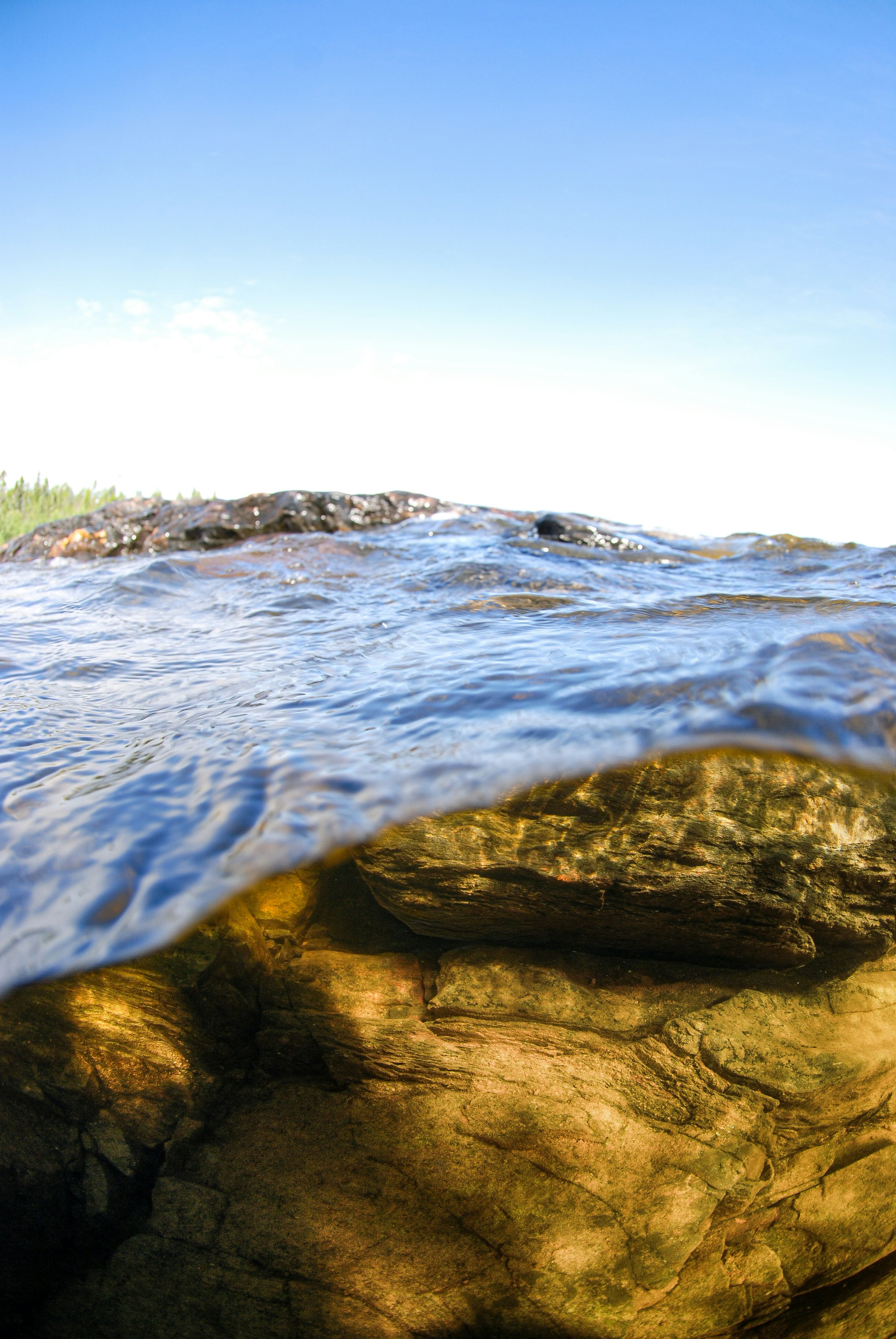 Peering Through a Glassy Crest: Shoreline Wave and Sunlit Rock