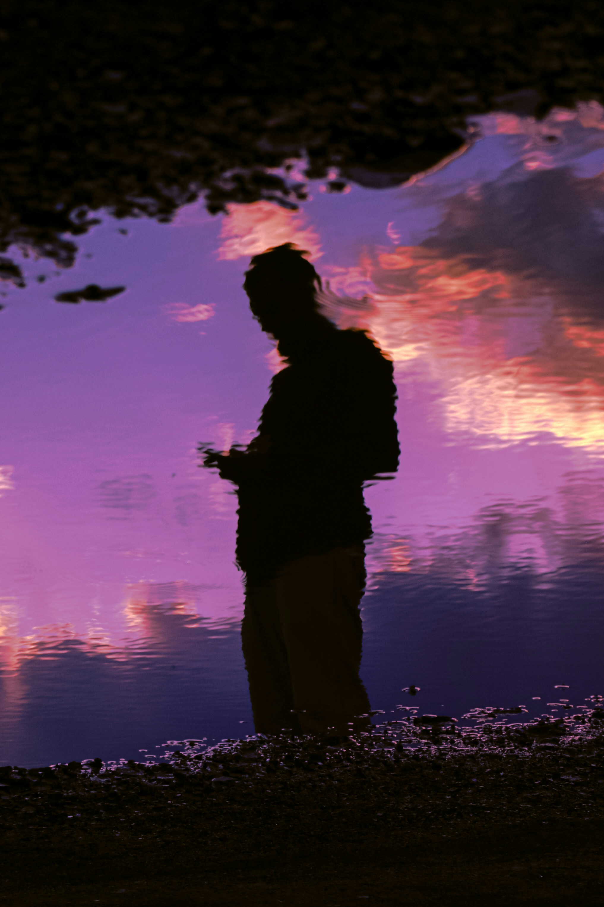 Silhouette at Sunset: A Contemplative Pose by Quiet Waters