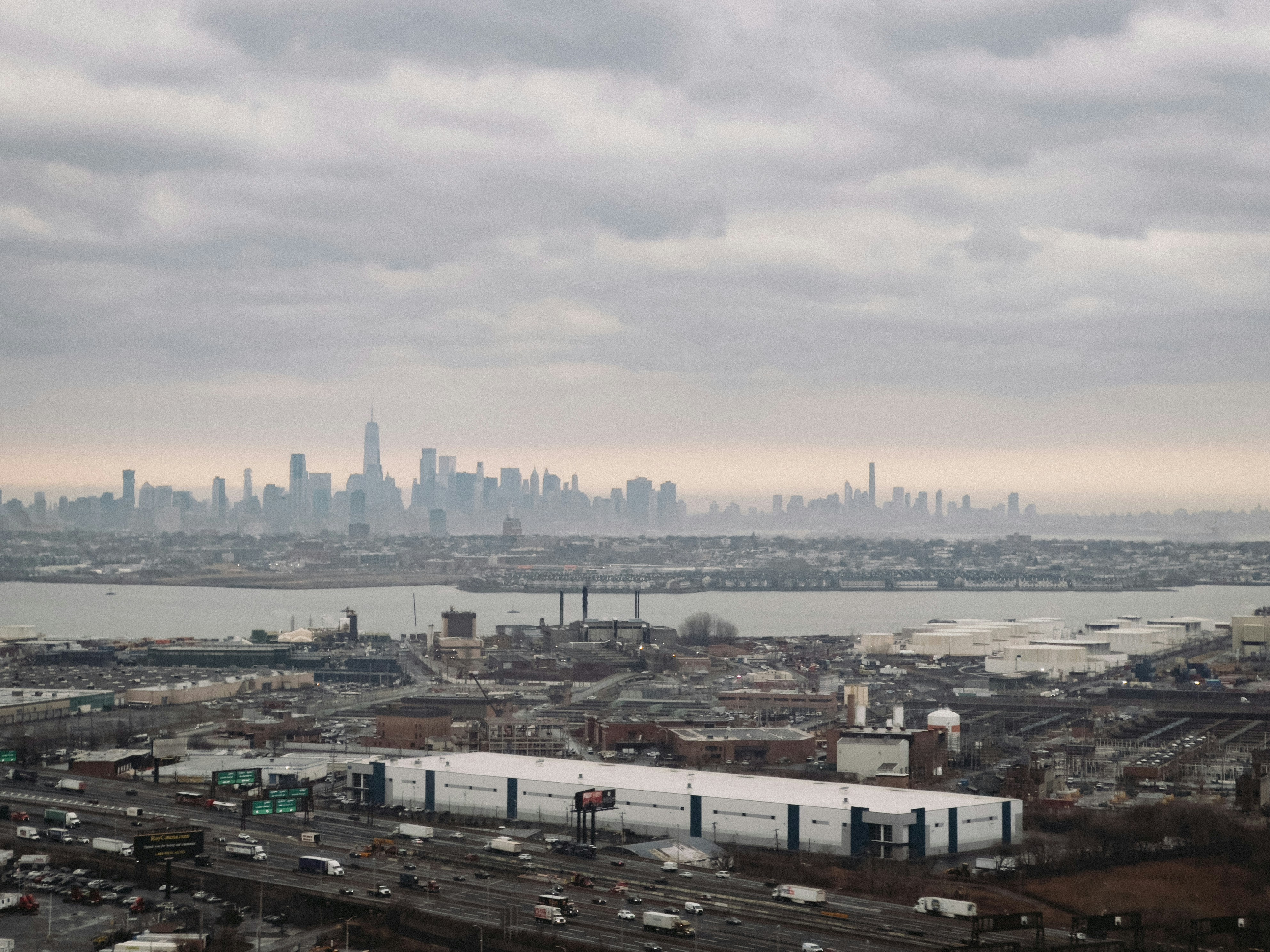 Industrial waterfront with distant skyline at low-contrast dawn