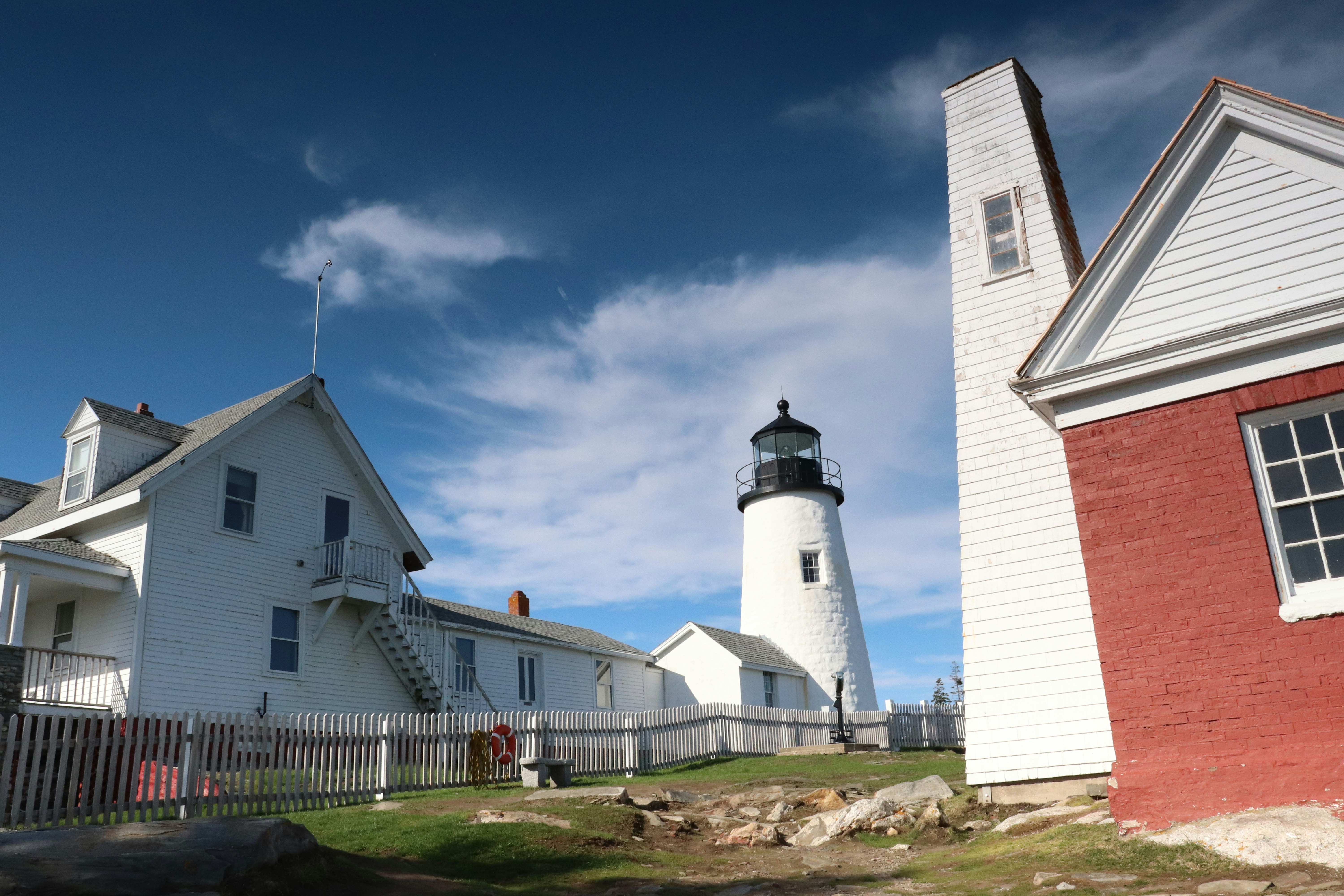 Lighthouse Row: White Houses Framing a Coastal Beacon