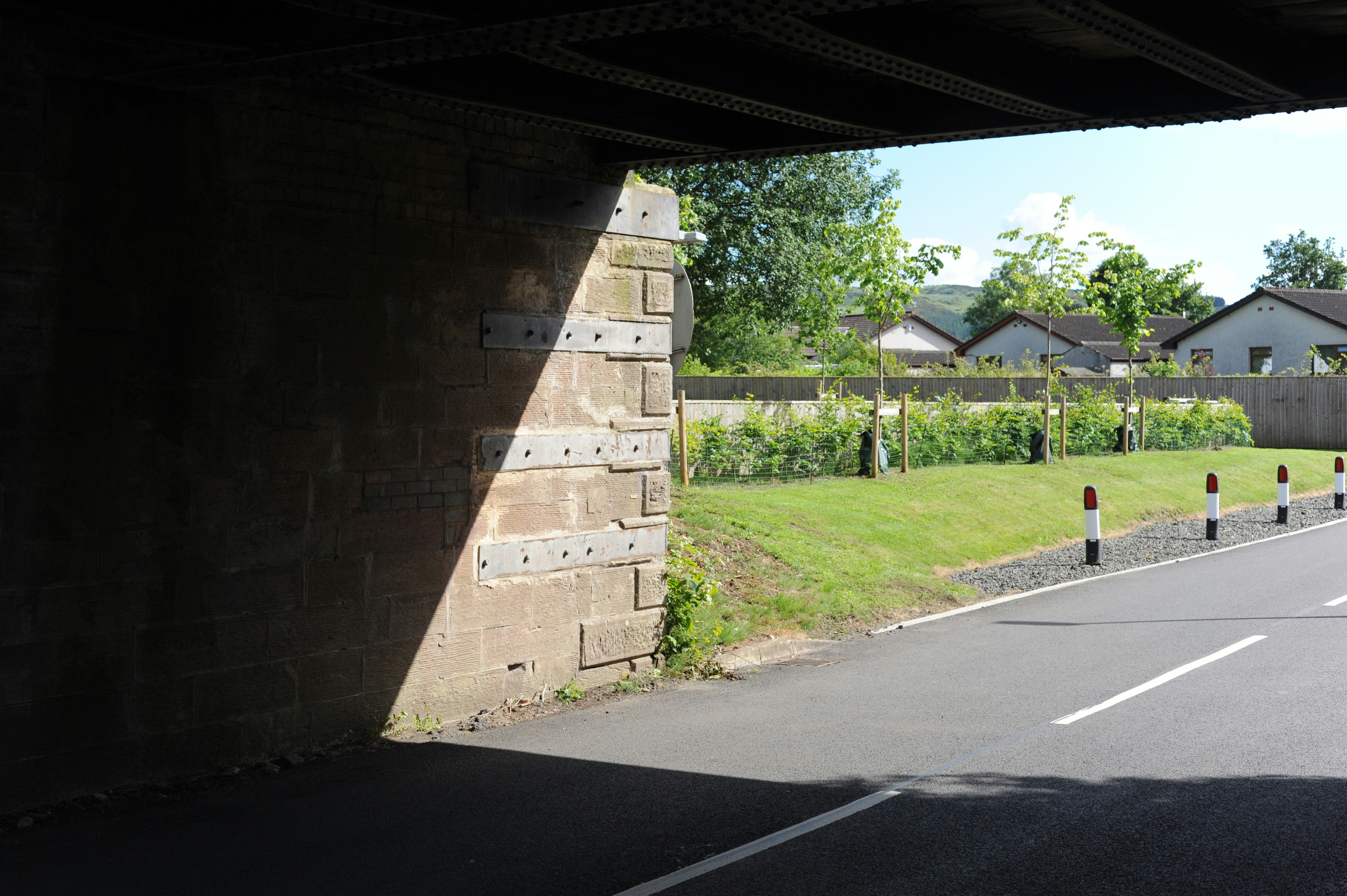 Shadowed Overpass Leading to Sunlit Park