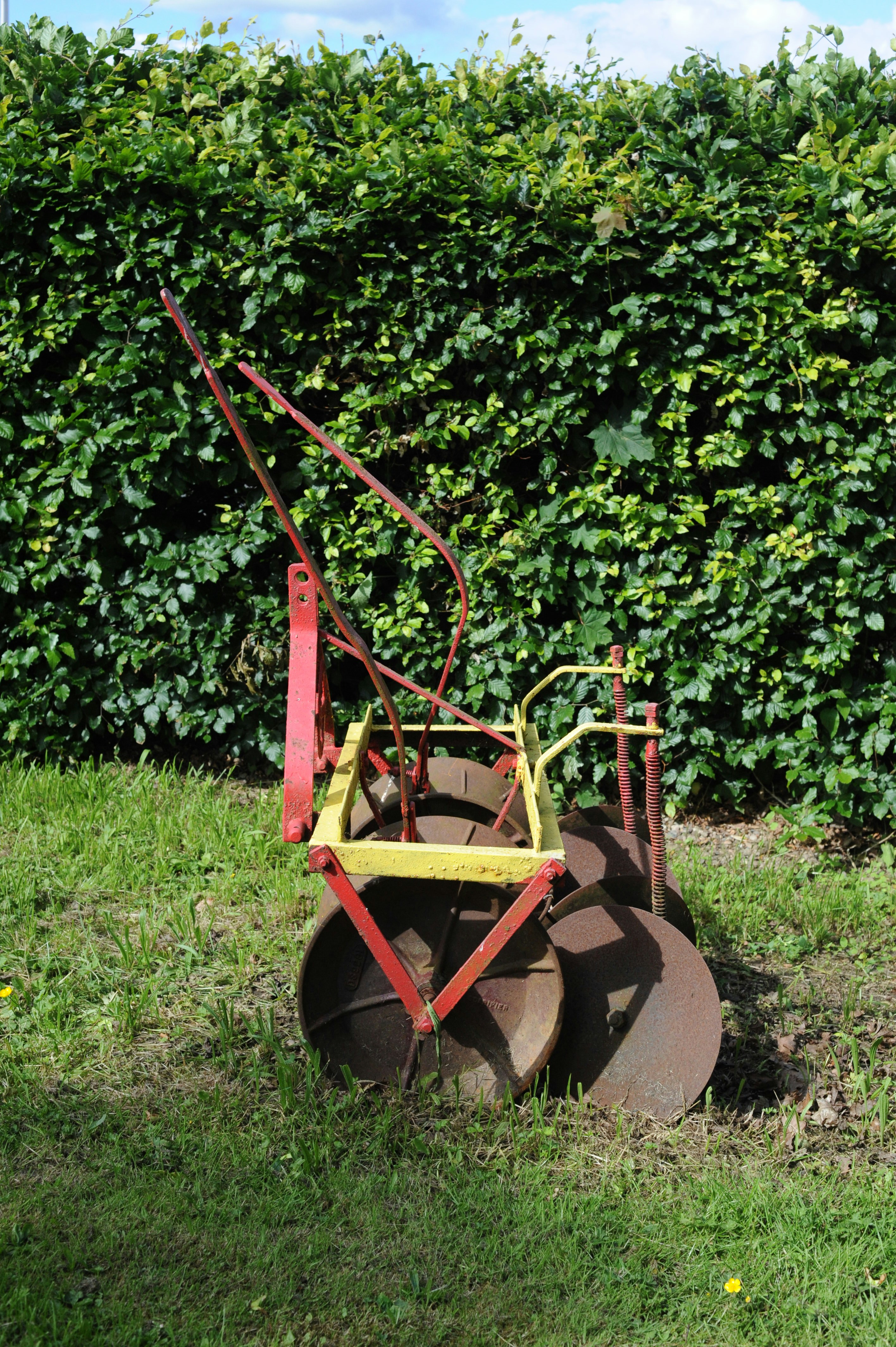 Red and Yellow Cultivator Lost in a Green Corridor