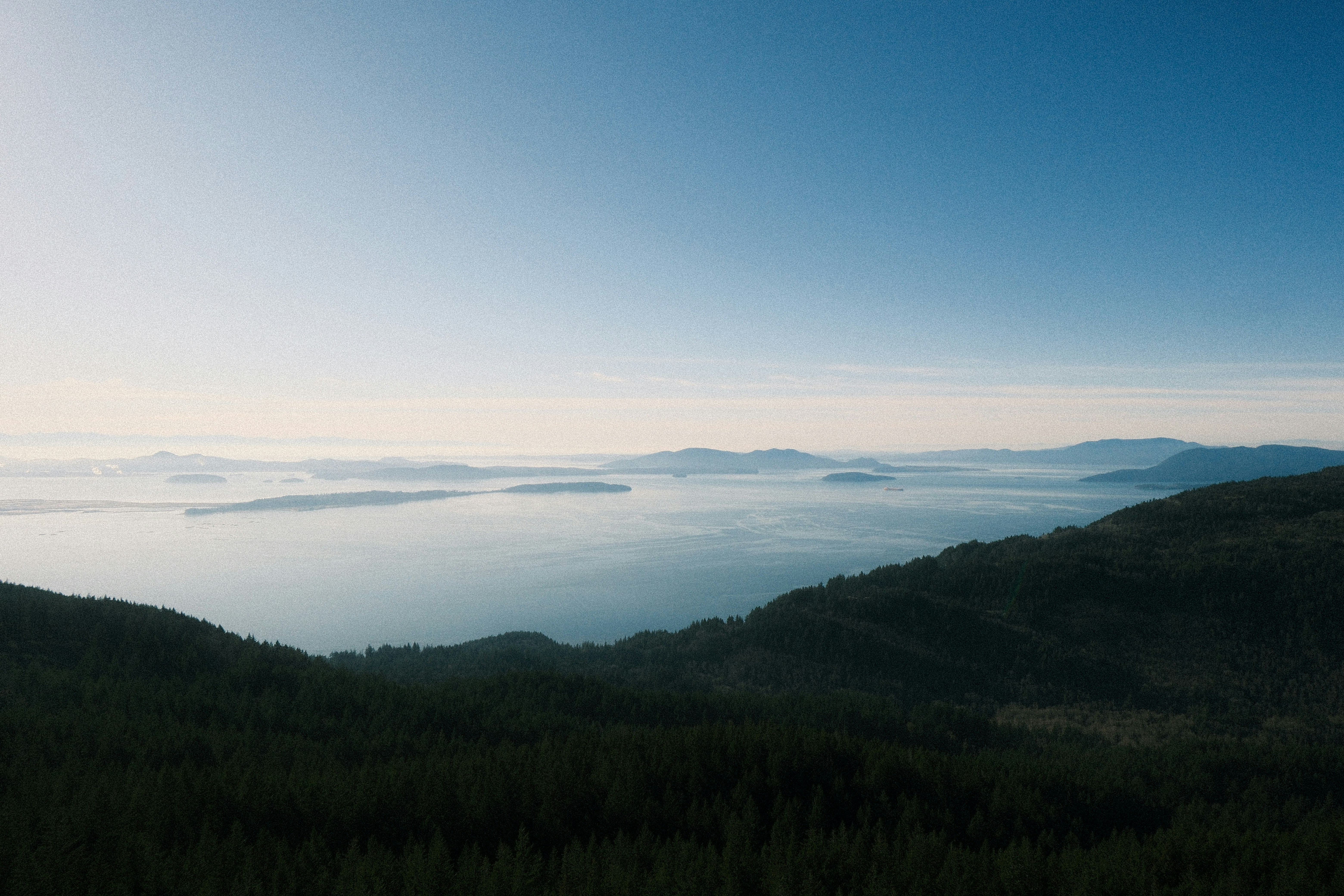 Horizon Whisper: Coastal Mountains Meet a Serene Sky