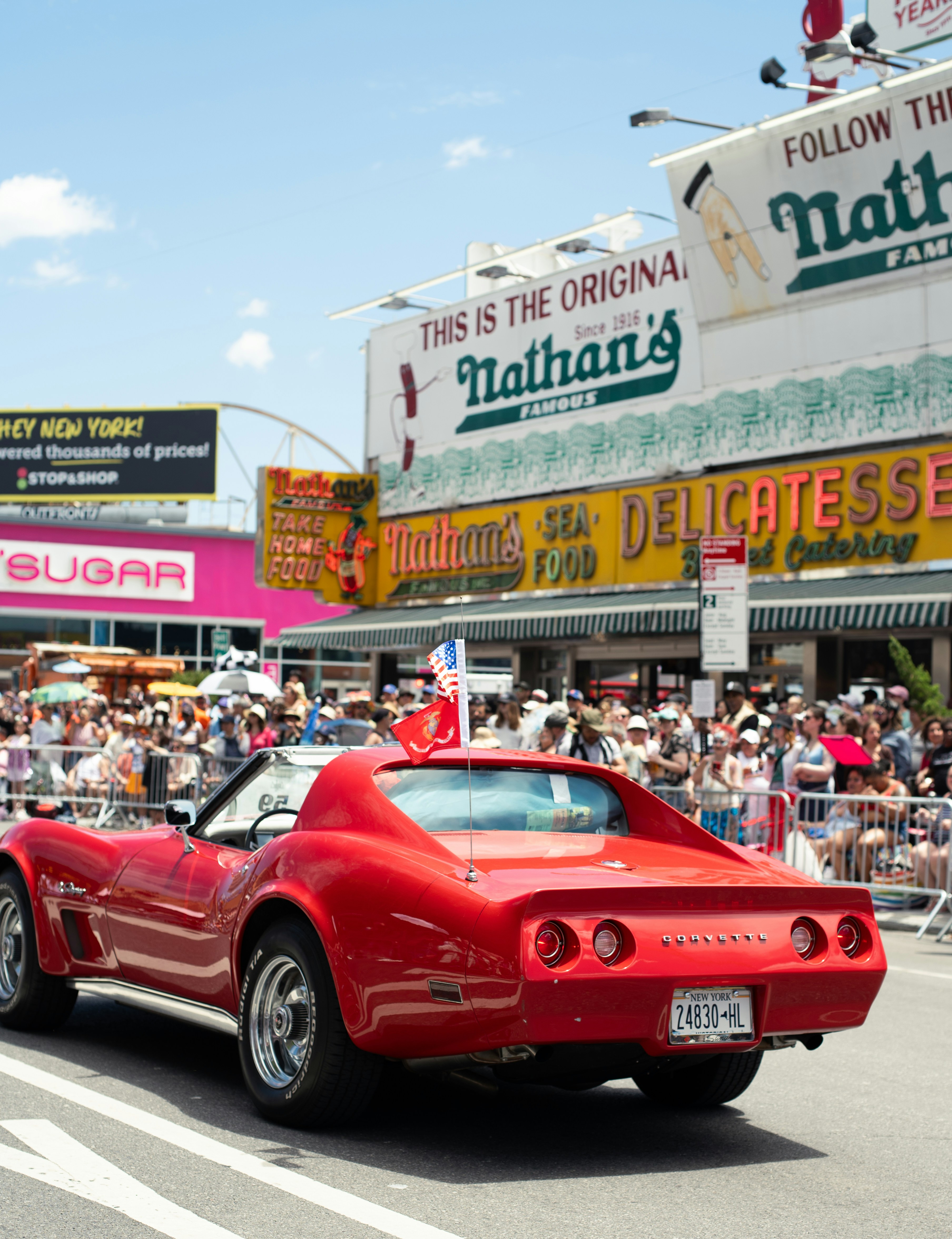 Red Classic at Nathan's: A Sunset Parade of Cars and Crowds