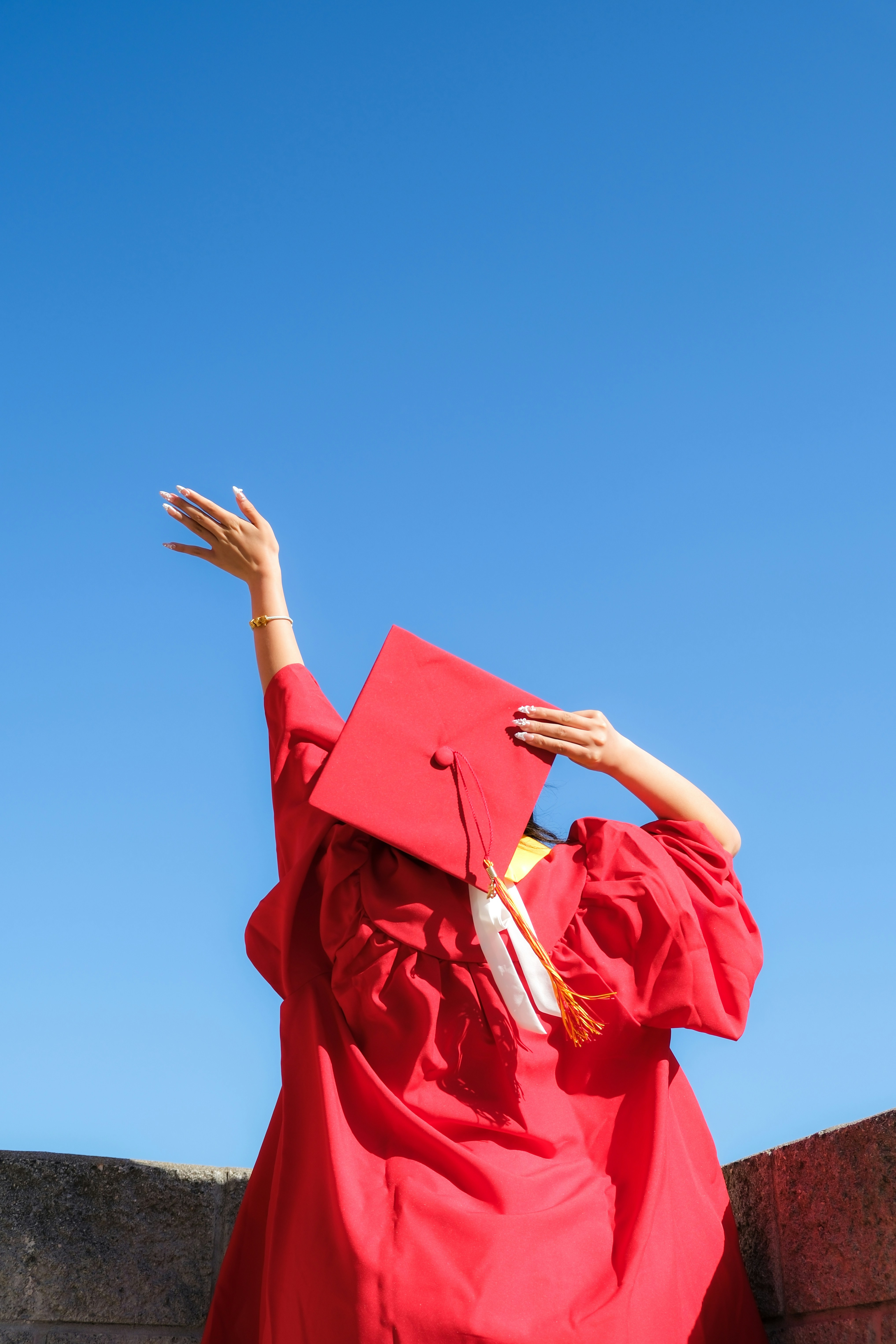 Red-Gown Celebration Under a Vast Blue Sky