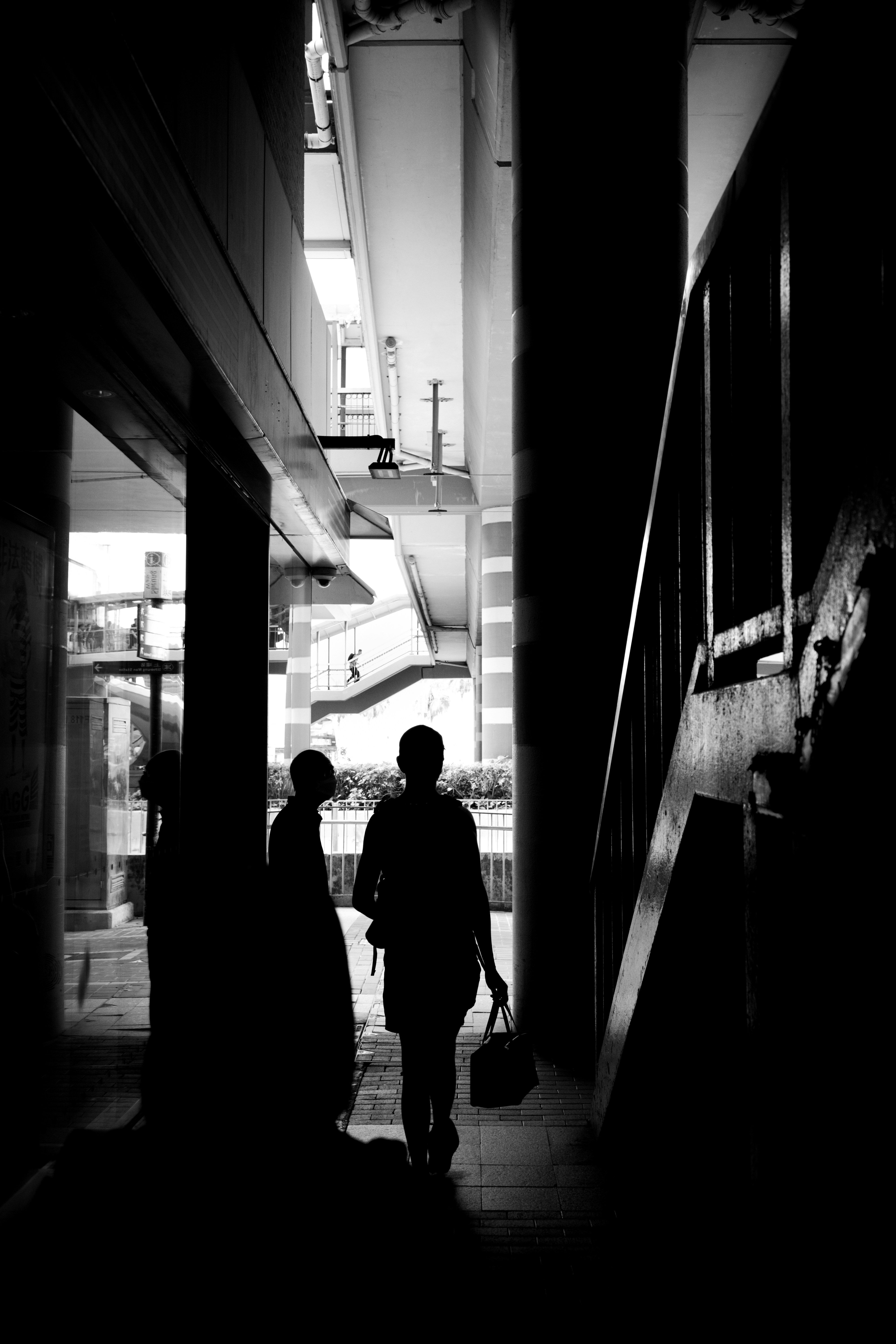 Silhouettes in a Narrow Transit: Evening in the Underpass