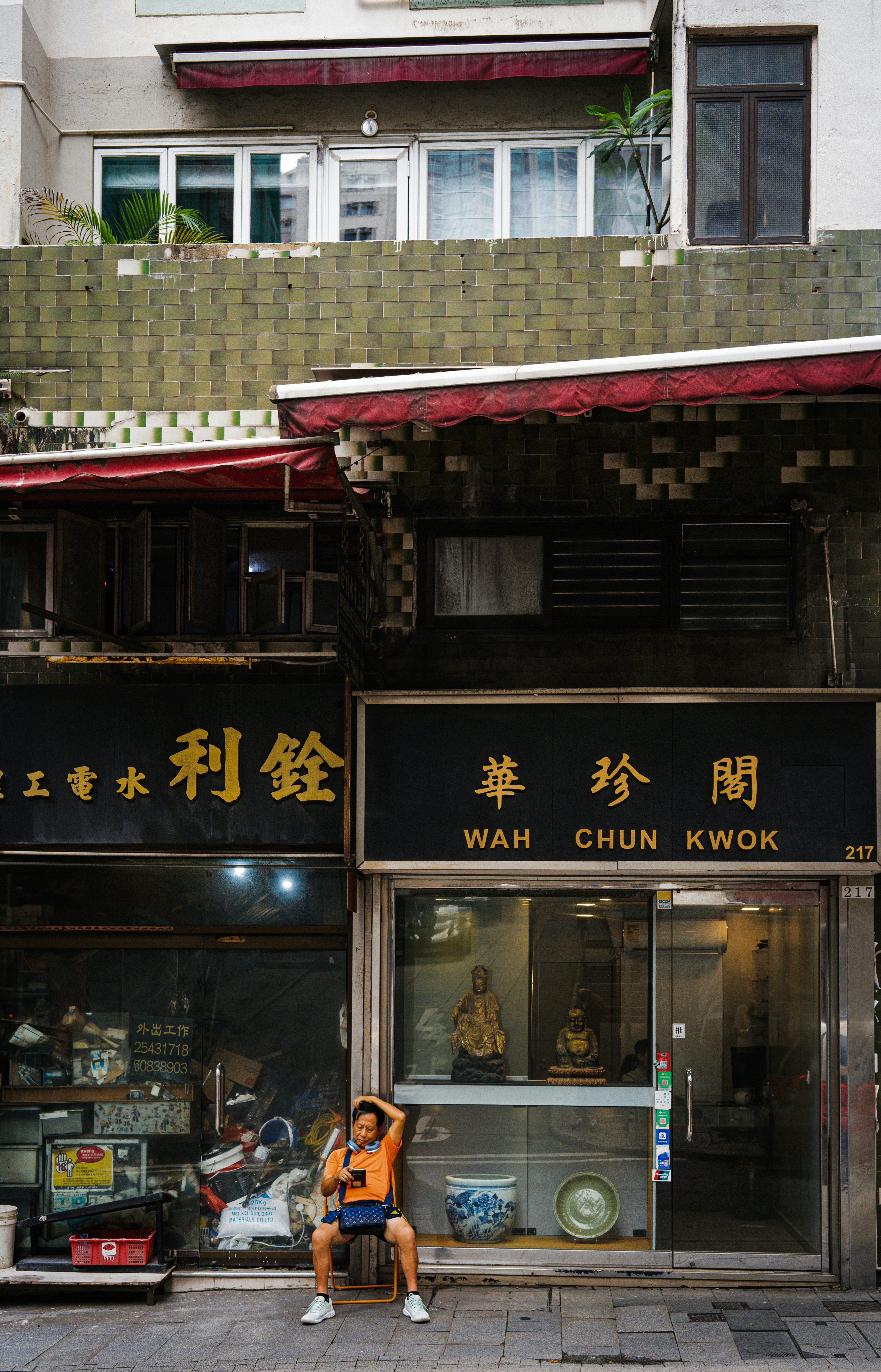 Street-side Shopper Sits Beneath Chinatown Facade