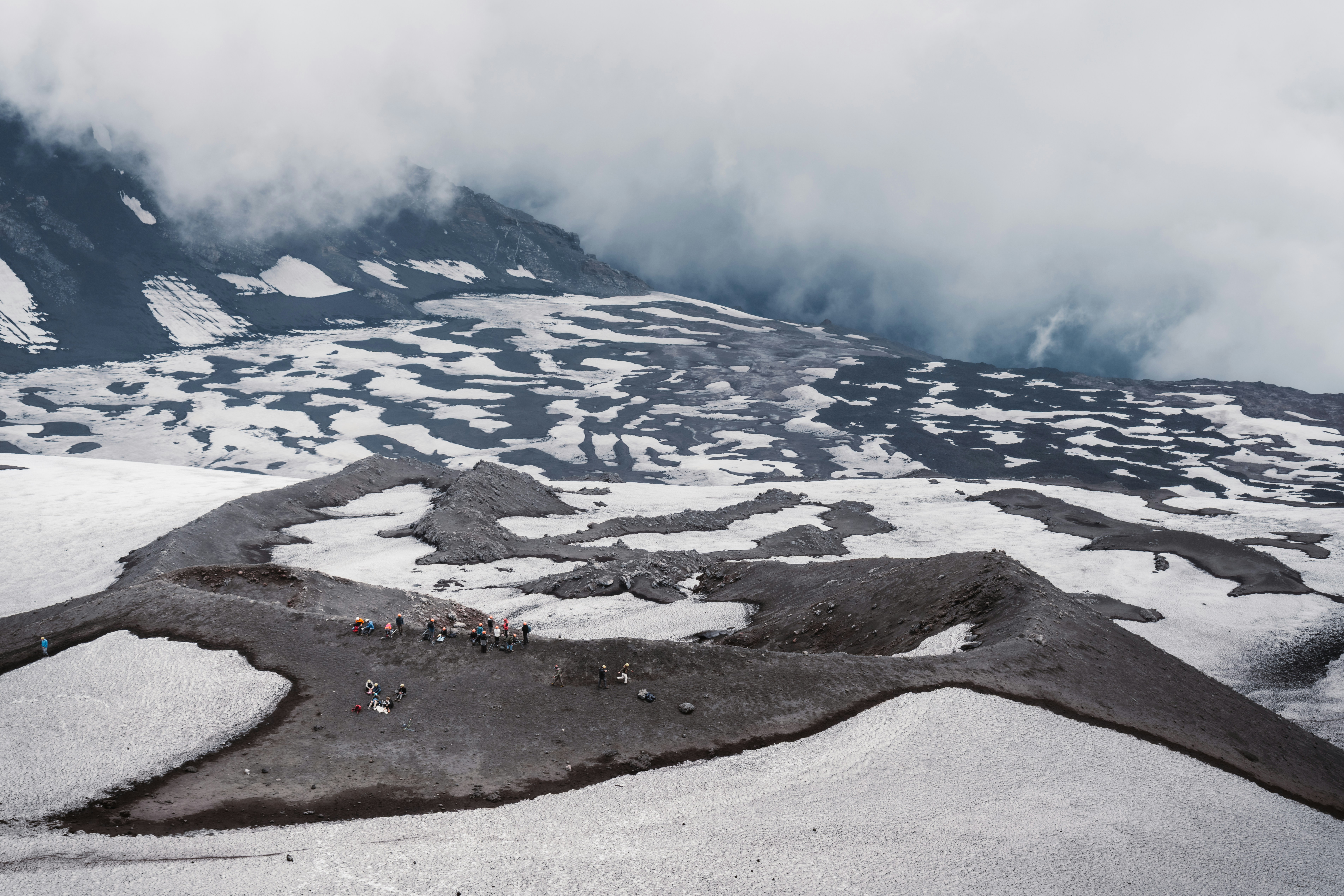 Trail of Dark Snow: Climbing Path Across a Glacier Rim