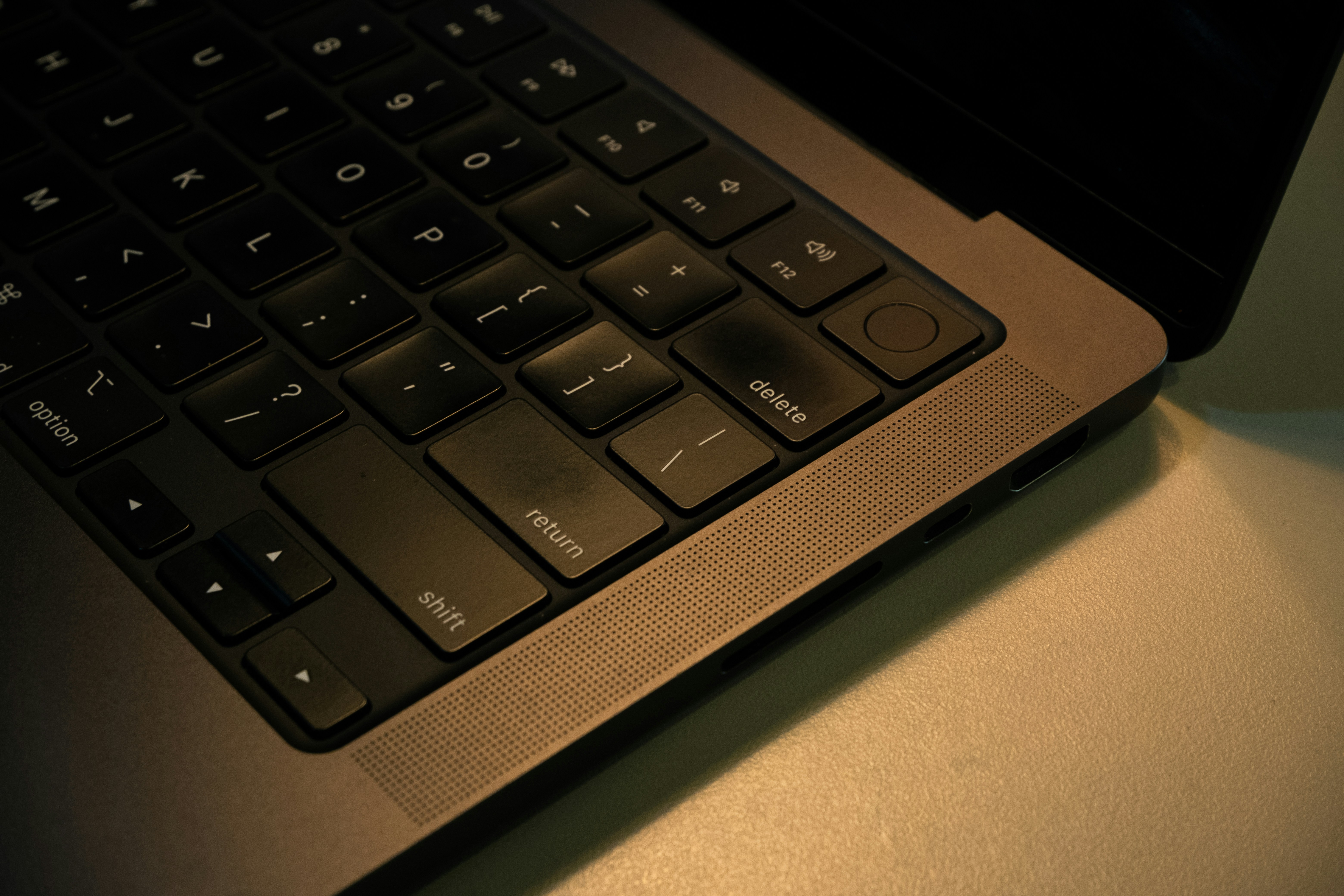 Chrome Meets Canvas: A Close-Up of a Laptop Keyboard Edge