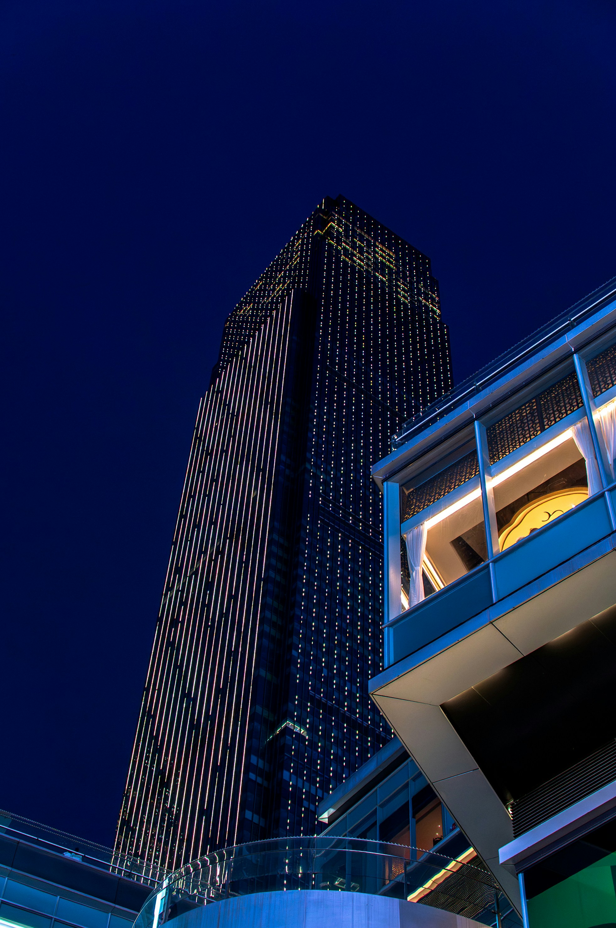 Night ascent: A neon-lit tower framed by glasswalkways