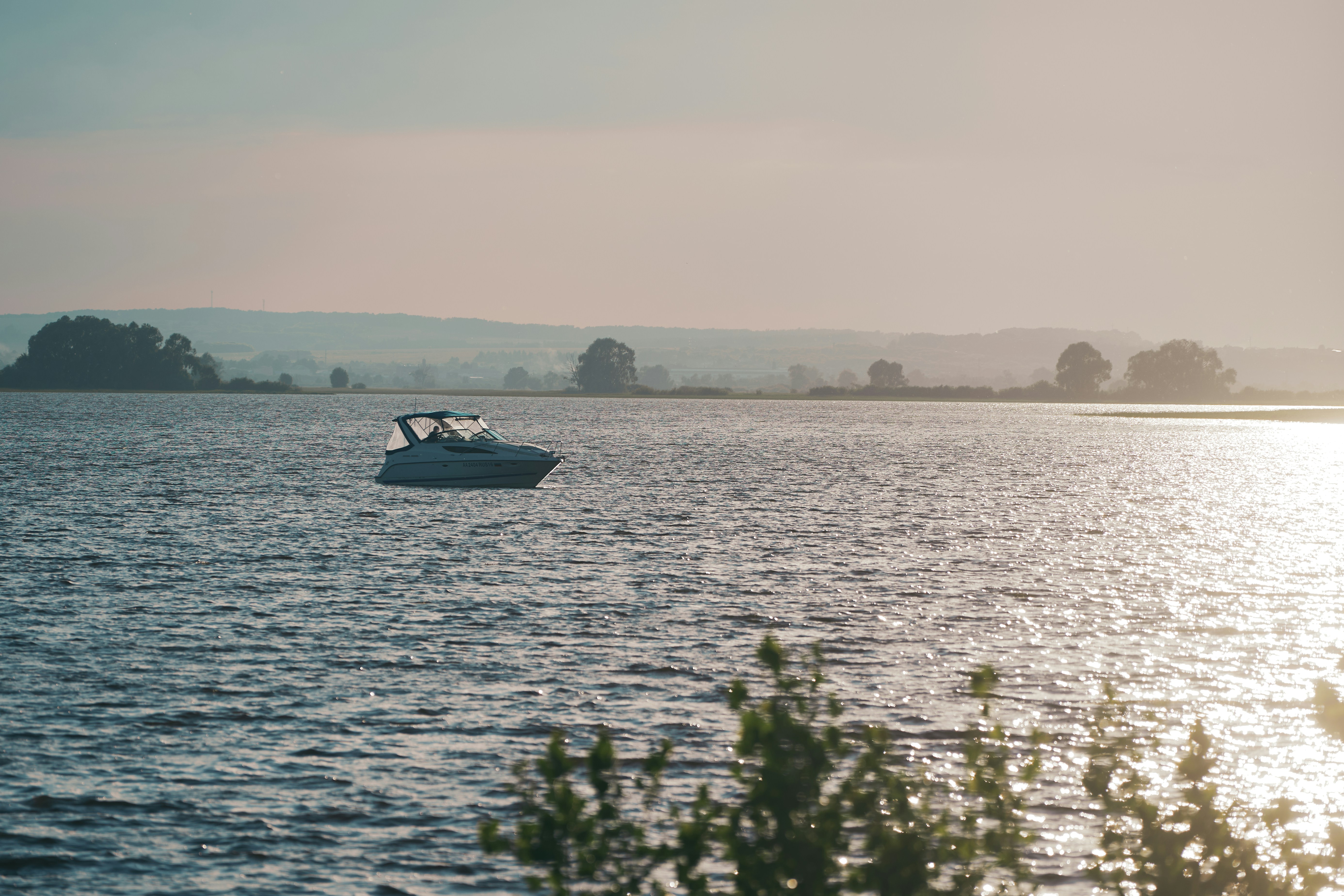 Boat Drifting on Quiet Lake at Golden Hour