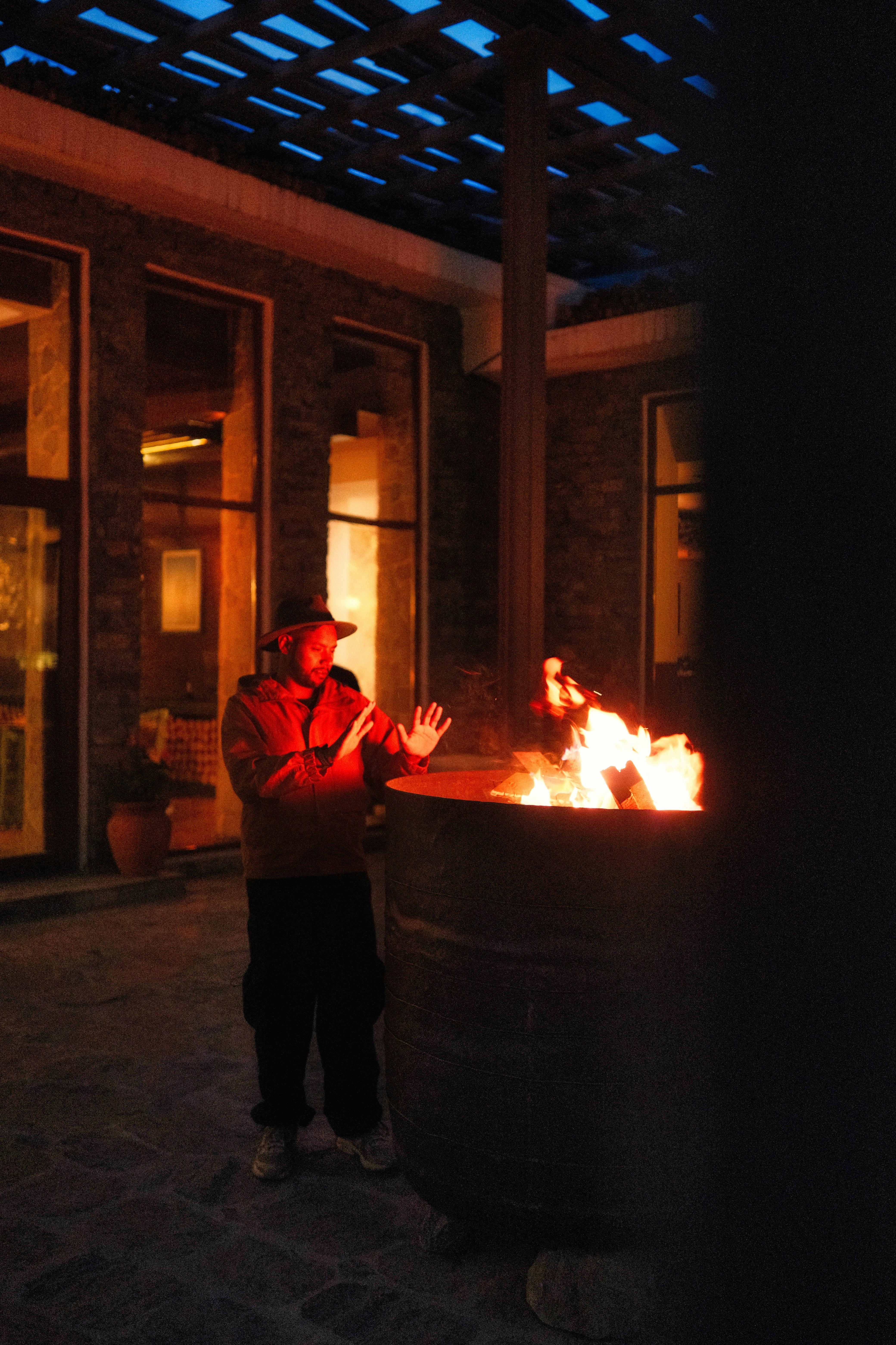 Huddle by the Flame: a quiet figure guarding a fire pit
