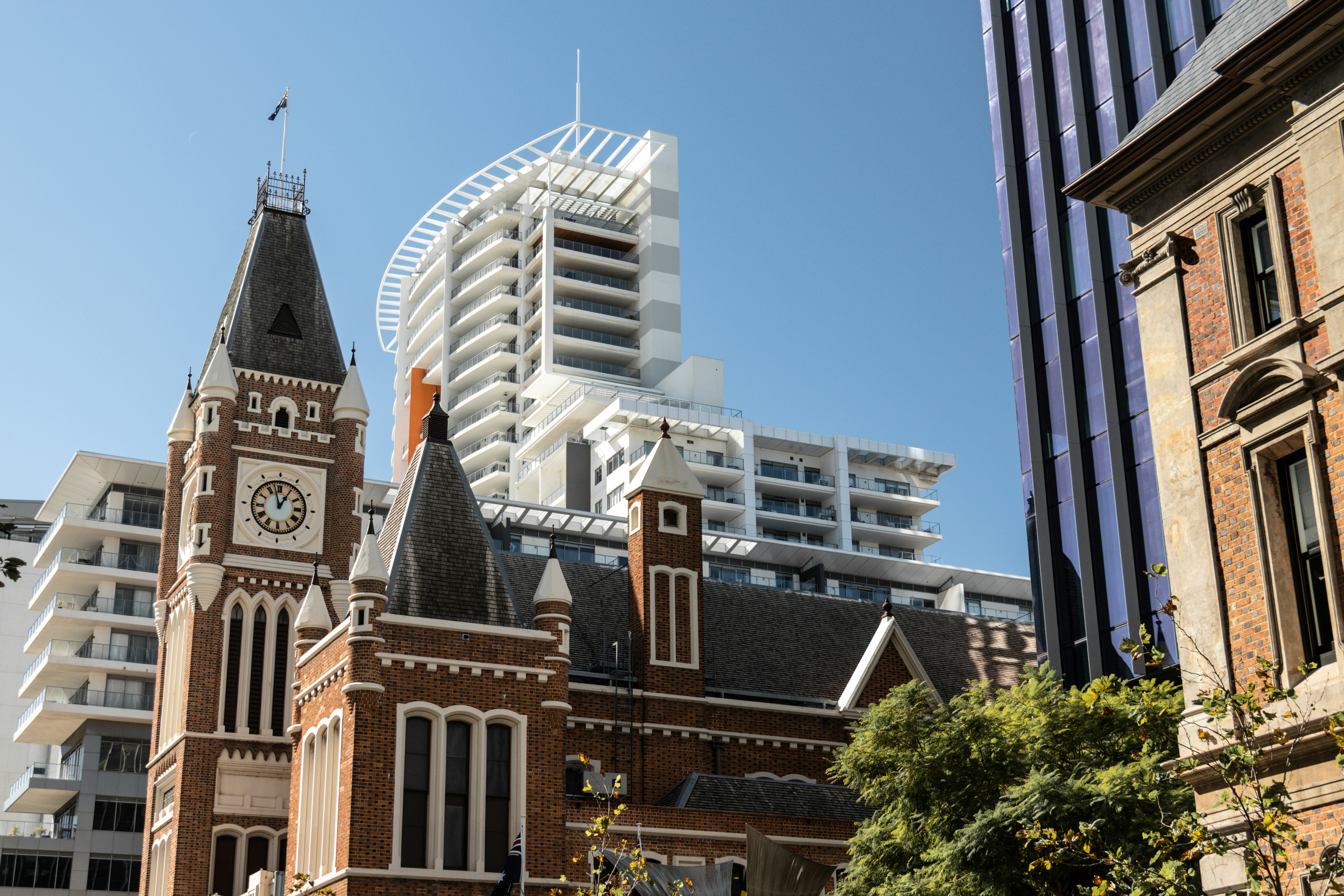 Cityscape Confluence: Historic Clock Tower Meets Modern Skyscraper