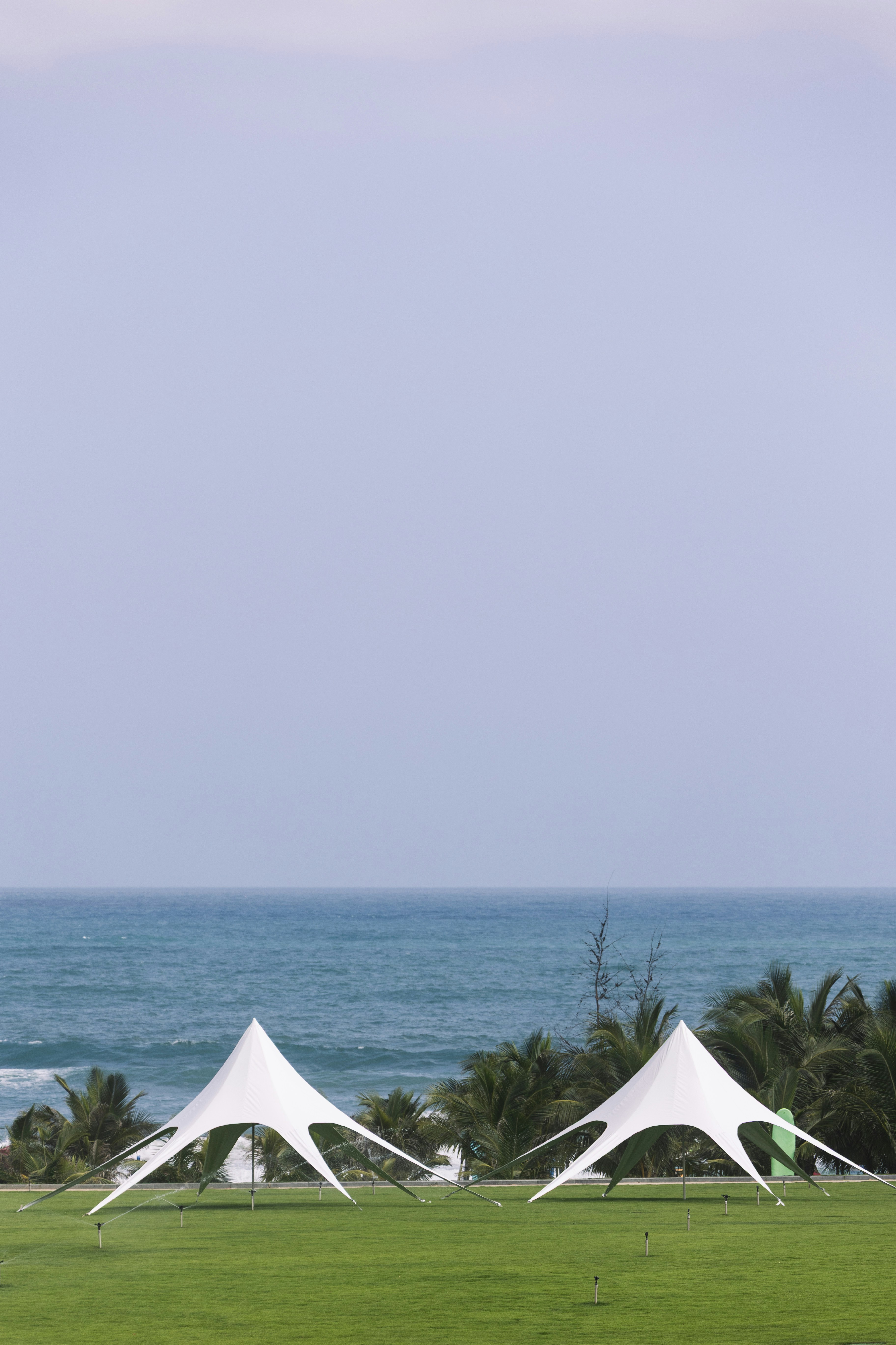 White Canopy Spires over Verdant Lawn by the Sea