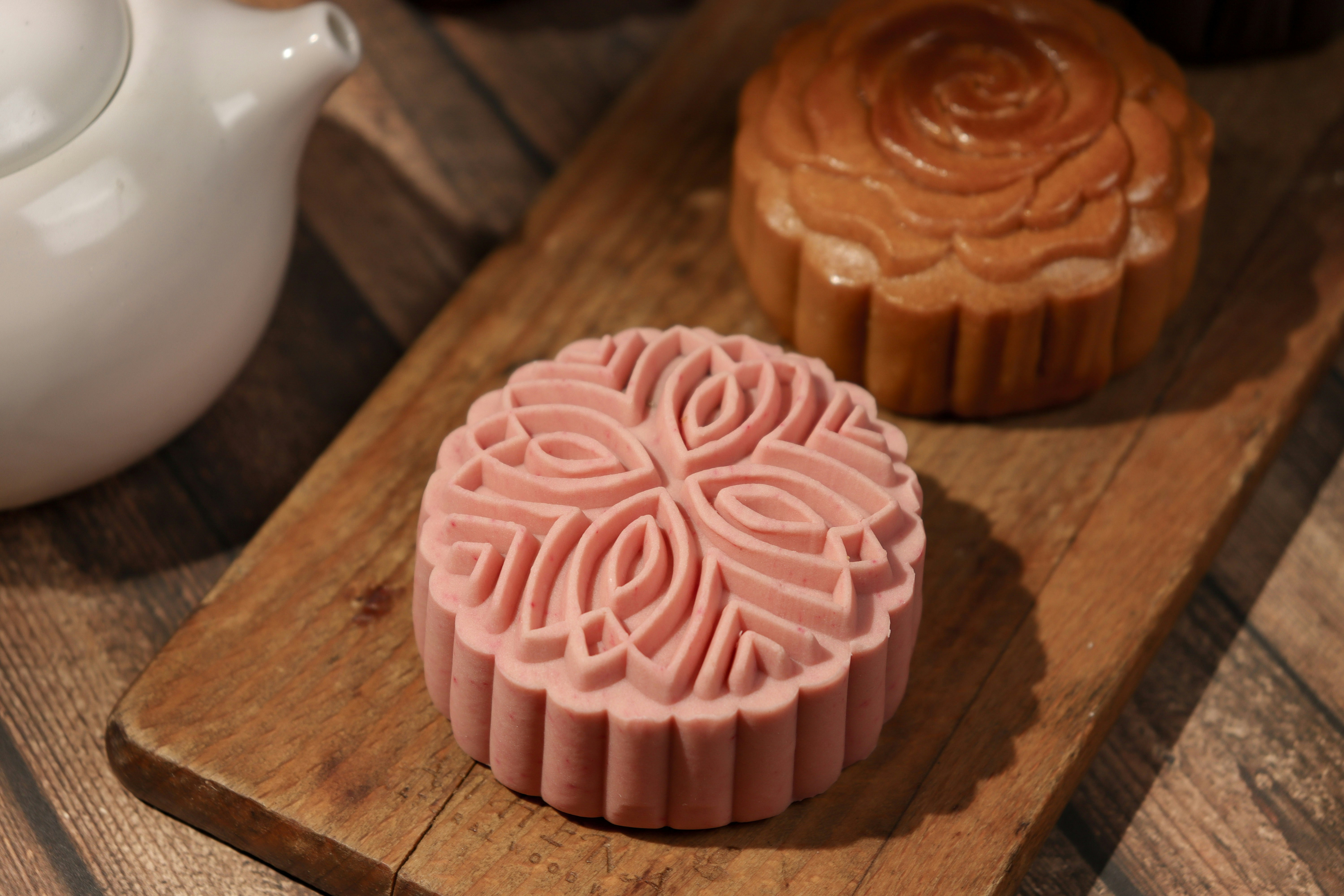 Floral Carved Mooncakes on a Wooden Platter under Soft Sunlight